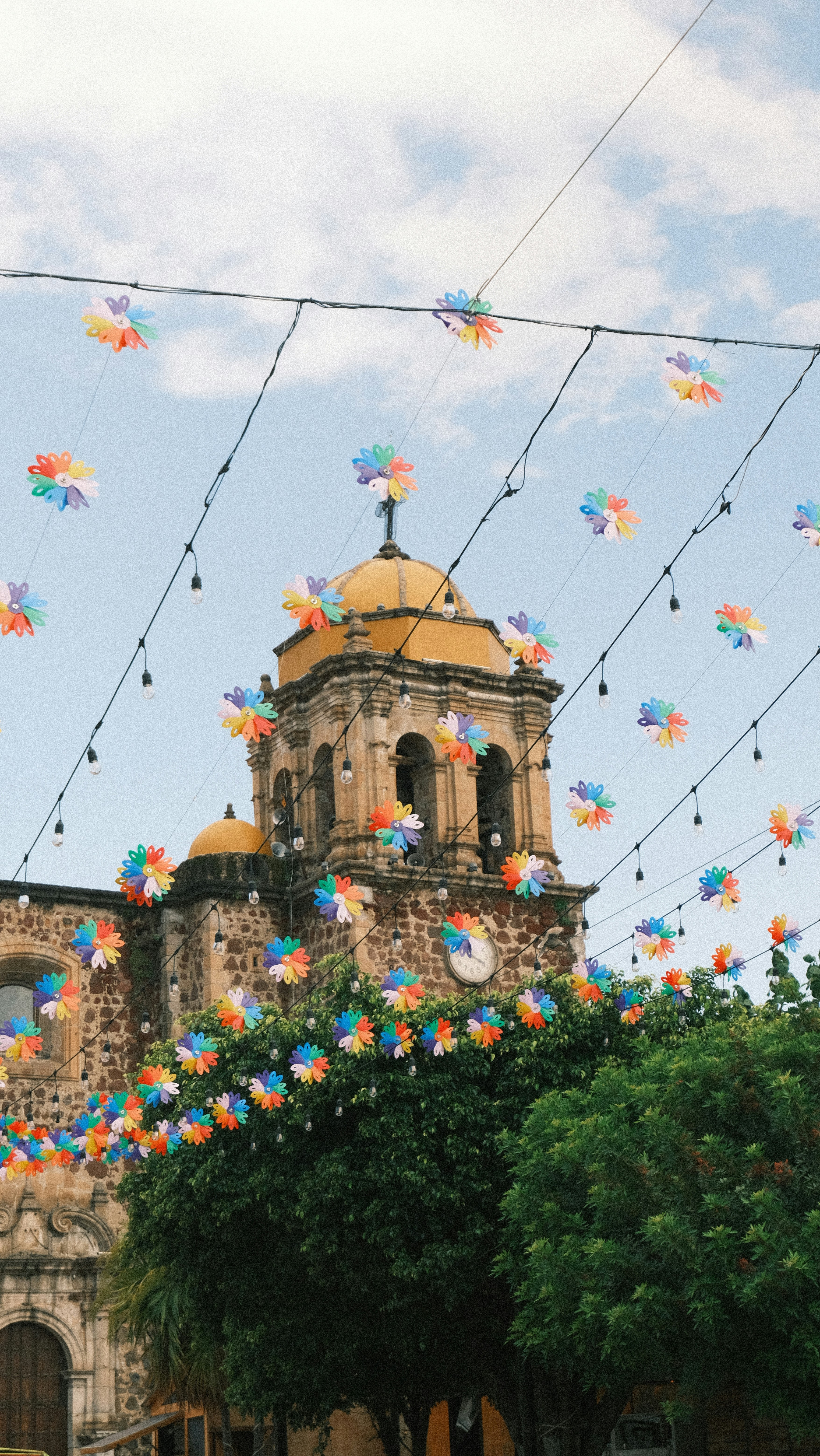 Colorful decorations strung across a street in front of a church.