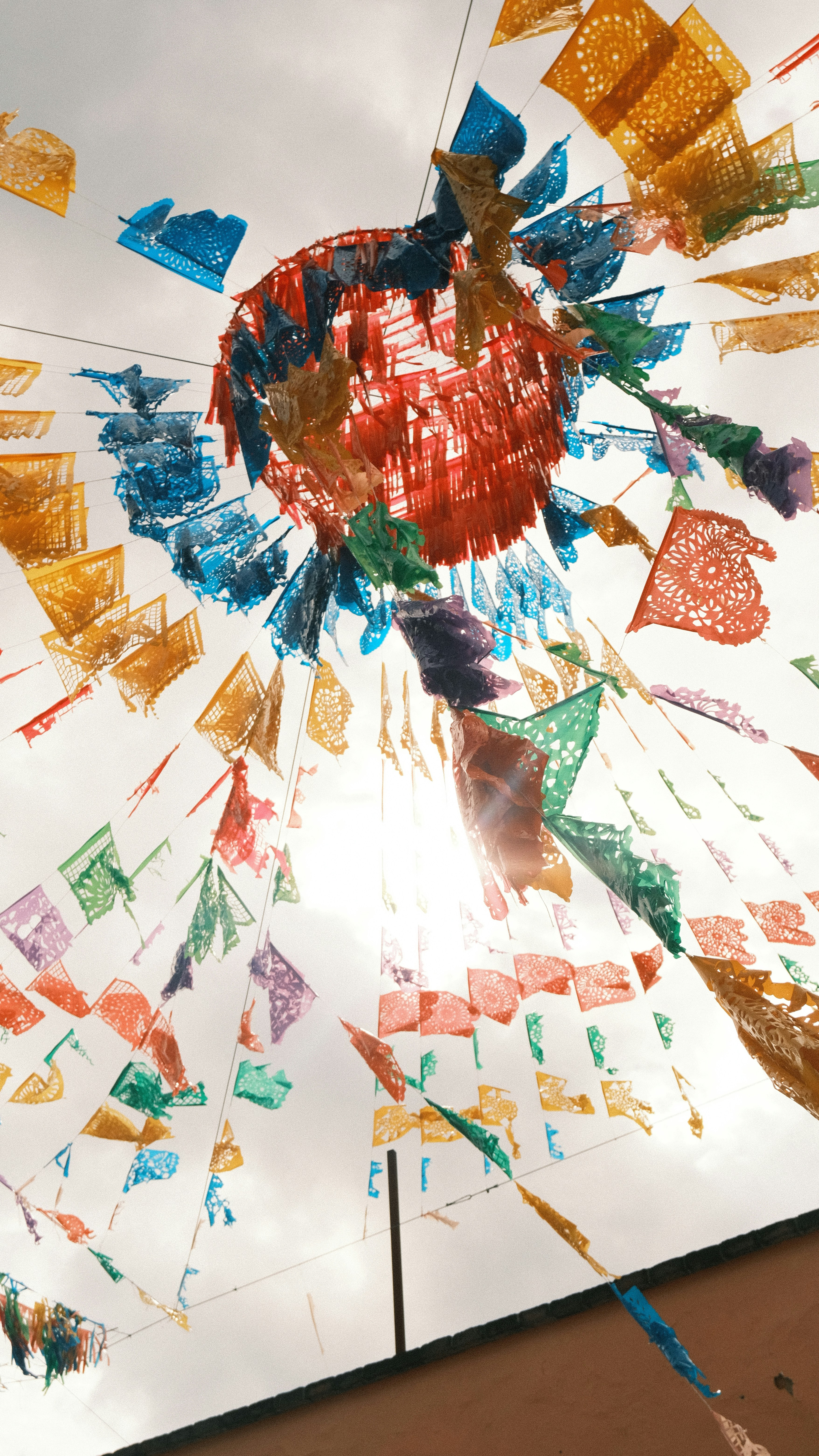 Colorful papel picado flags strung against a bright sky.