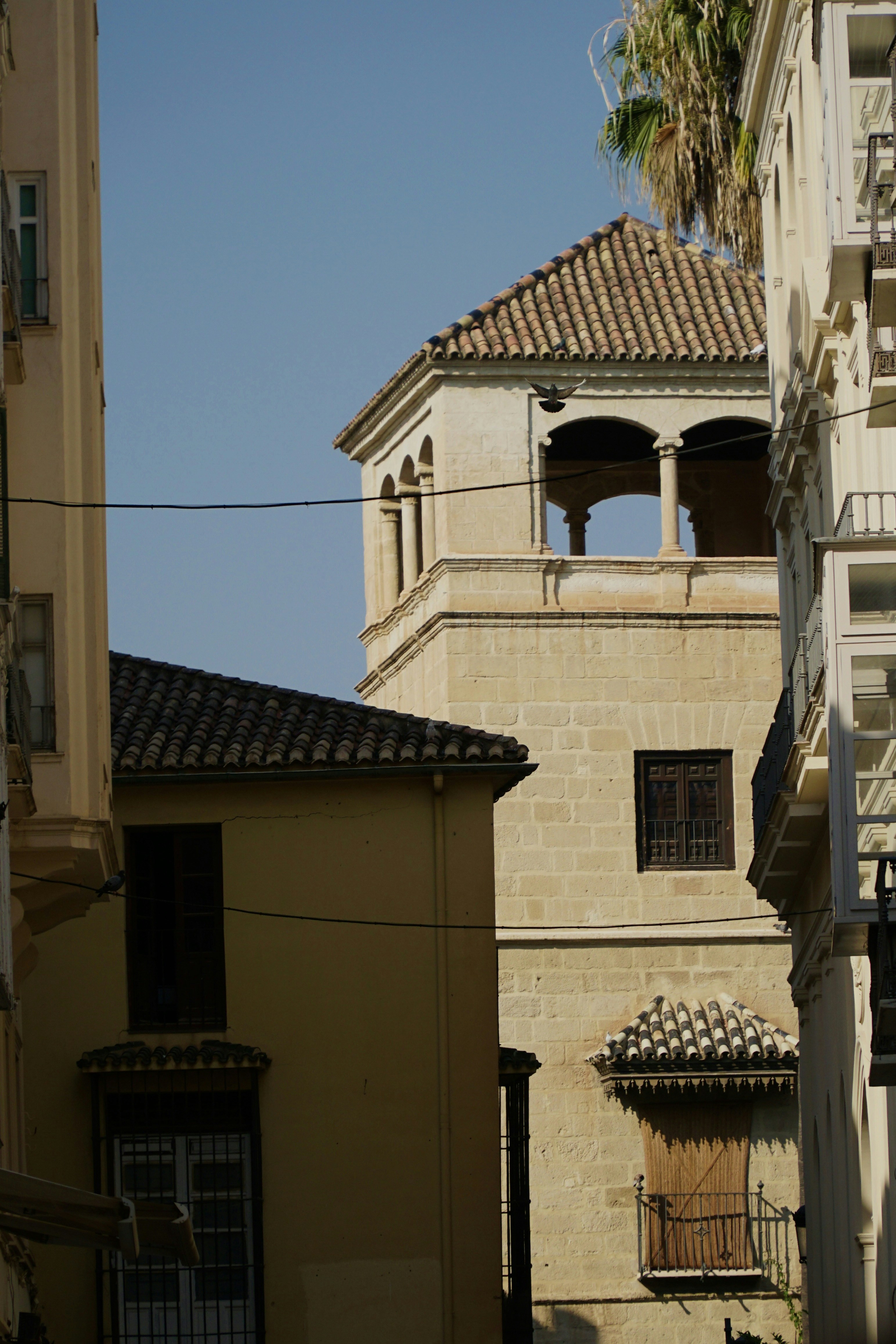 Historic stone tower with arched windows and tiled roof.