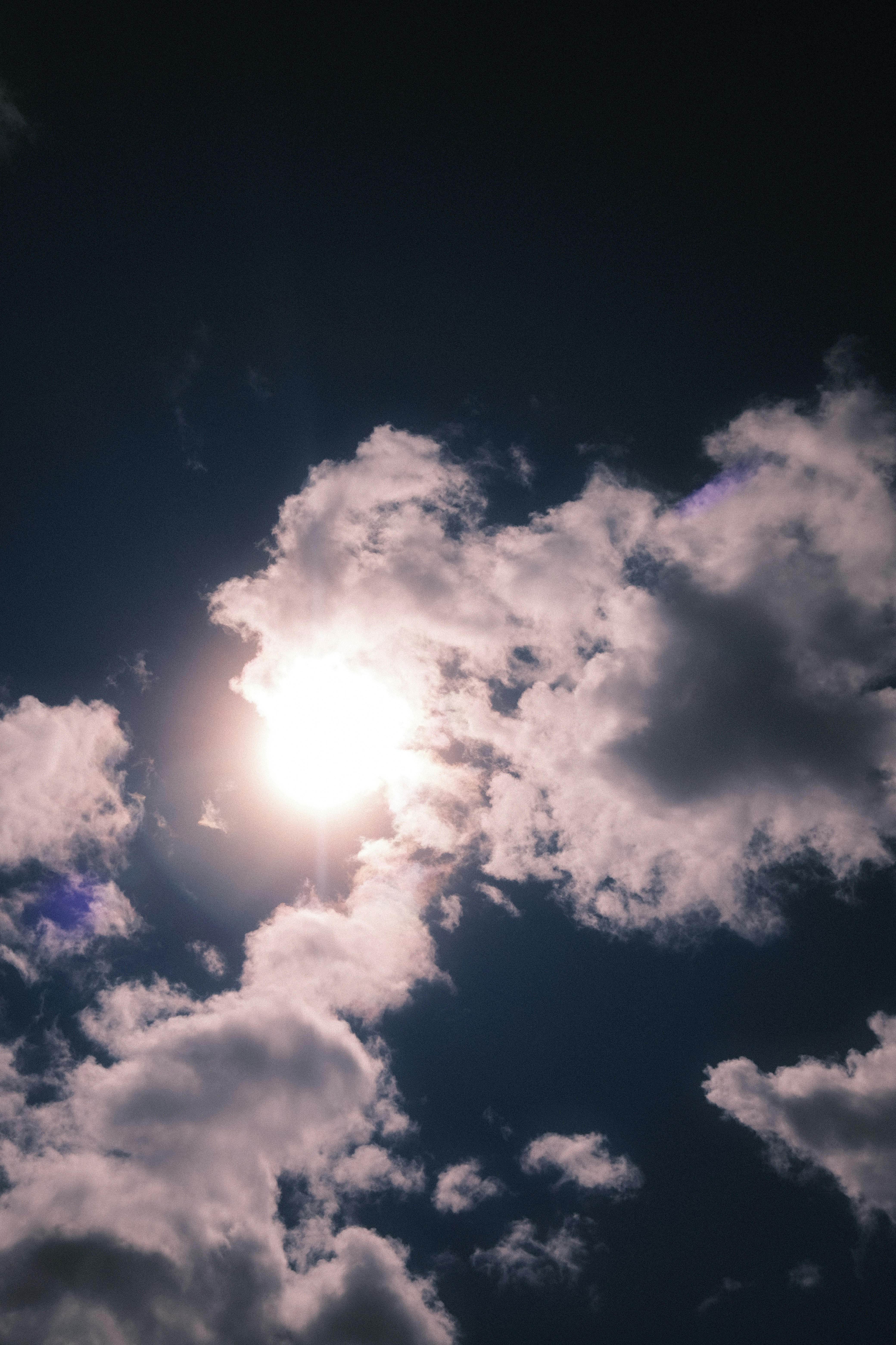 Sun shining through dramatic clouds in a dark sky