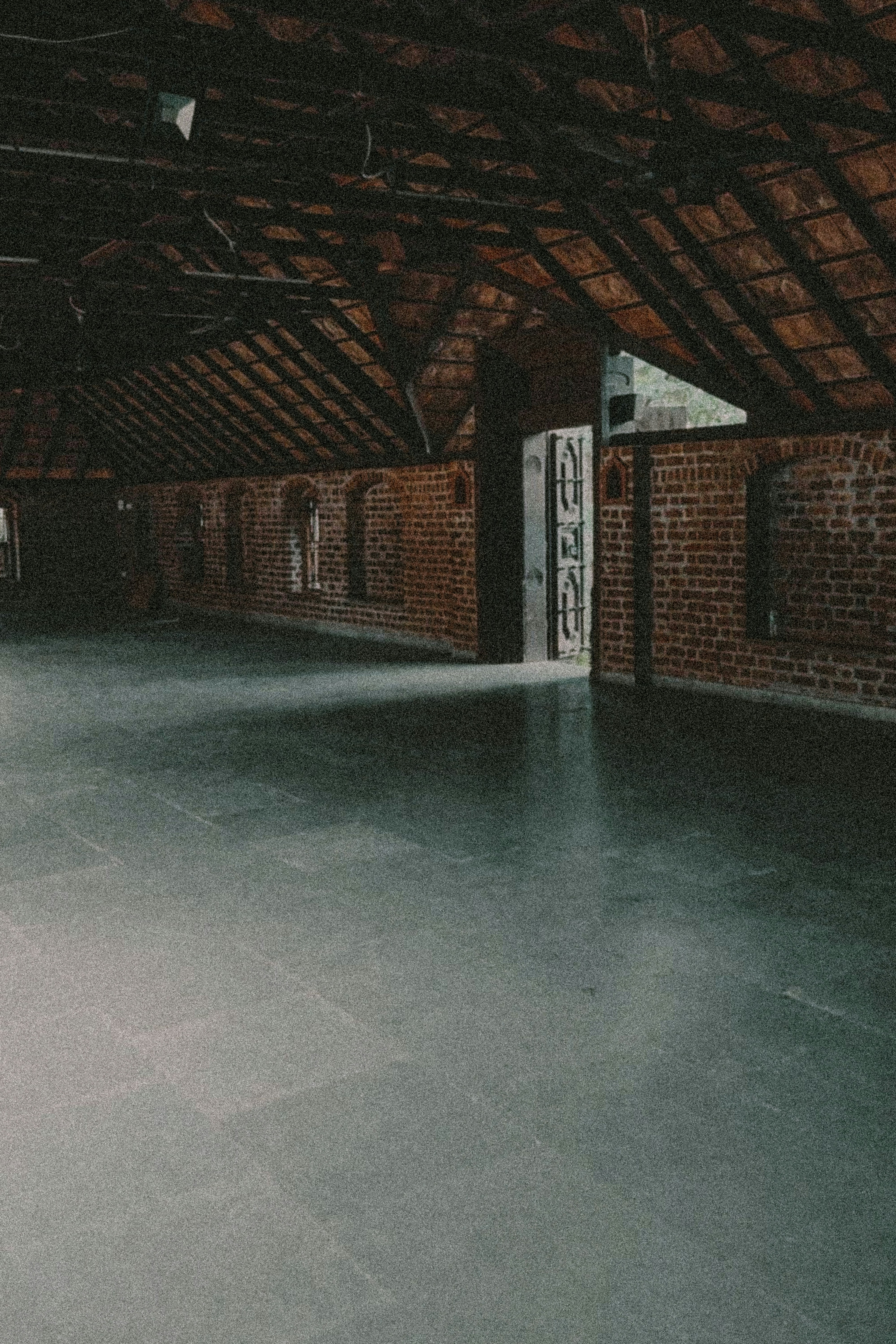 traditional heritage structure with stone flooring, exposed brick walls, and sloping wooden roofs | Empty room with brick walls and wooden ceiling