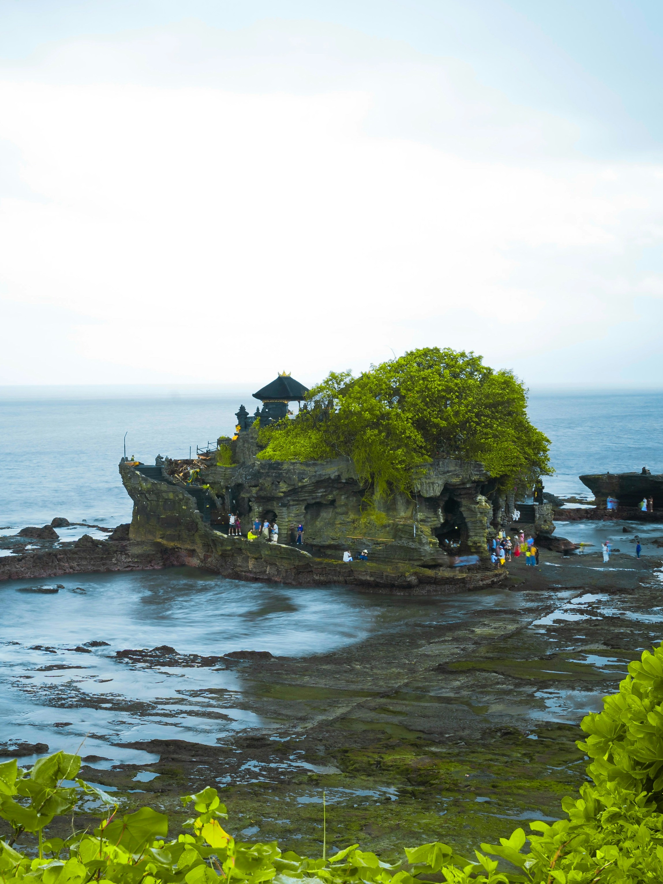 Tanah Lot Tample | Temple on a rocky island surrounded by the ocean.
