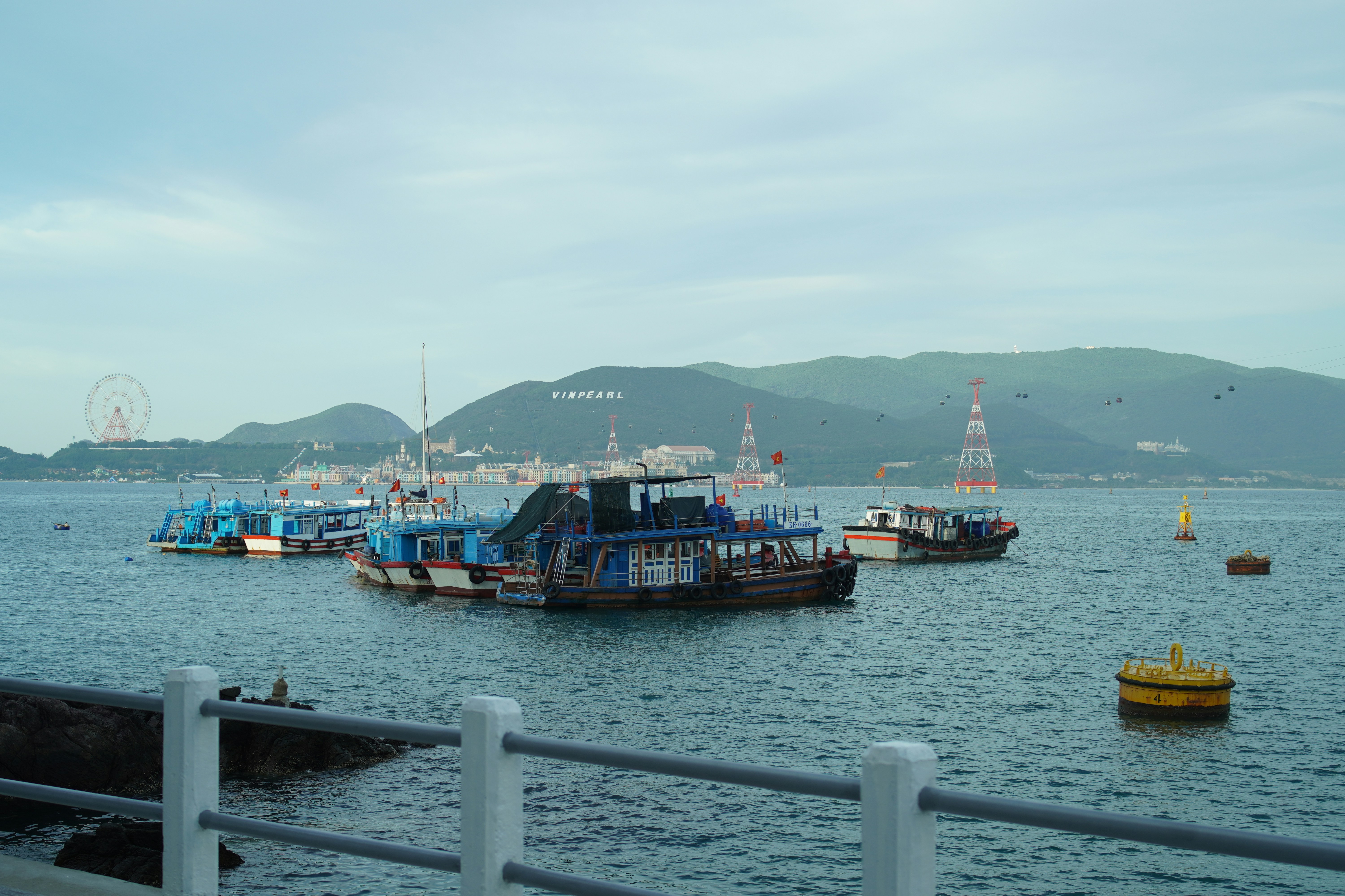 Boats floating on the water with distant city skyline.