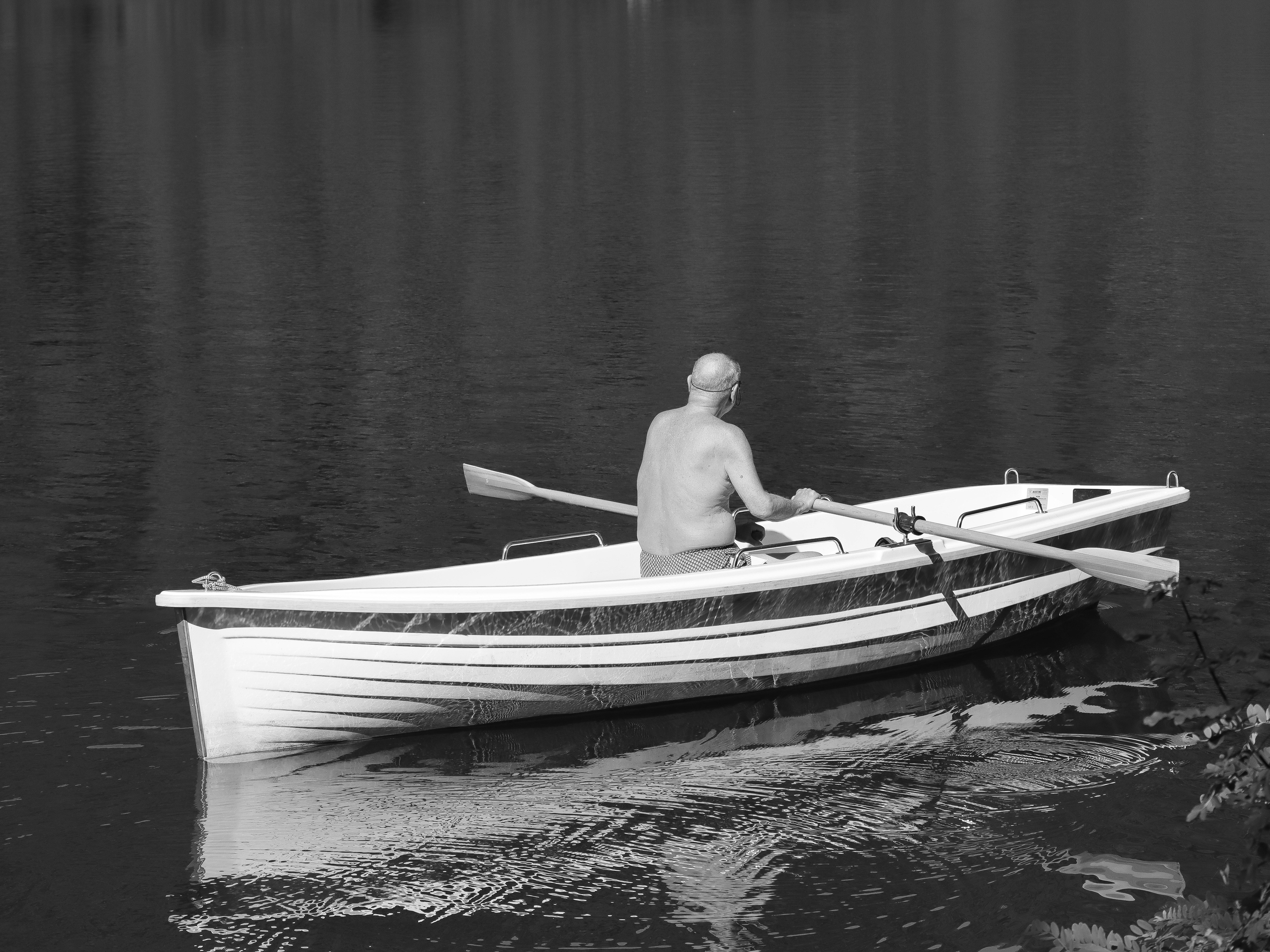 Man rowing a boat on calm water