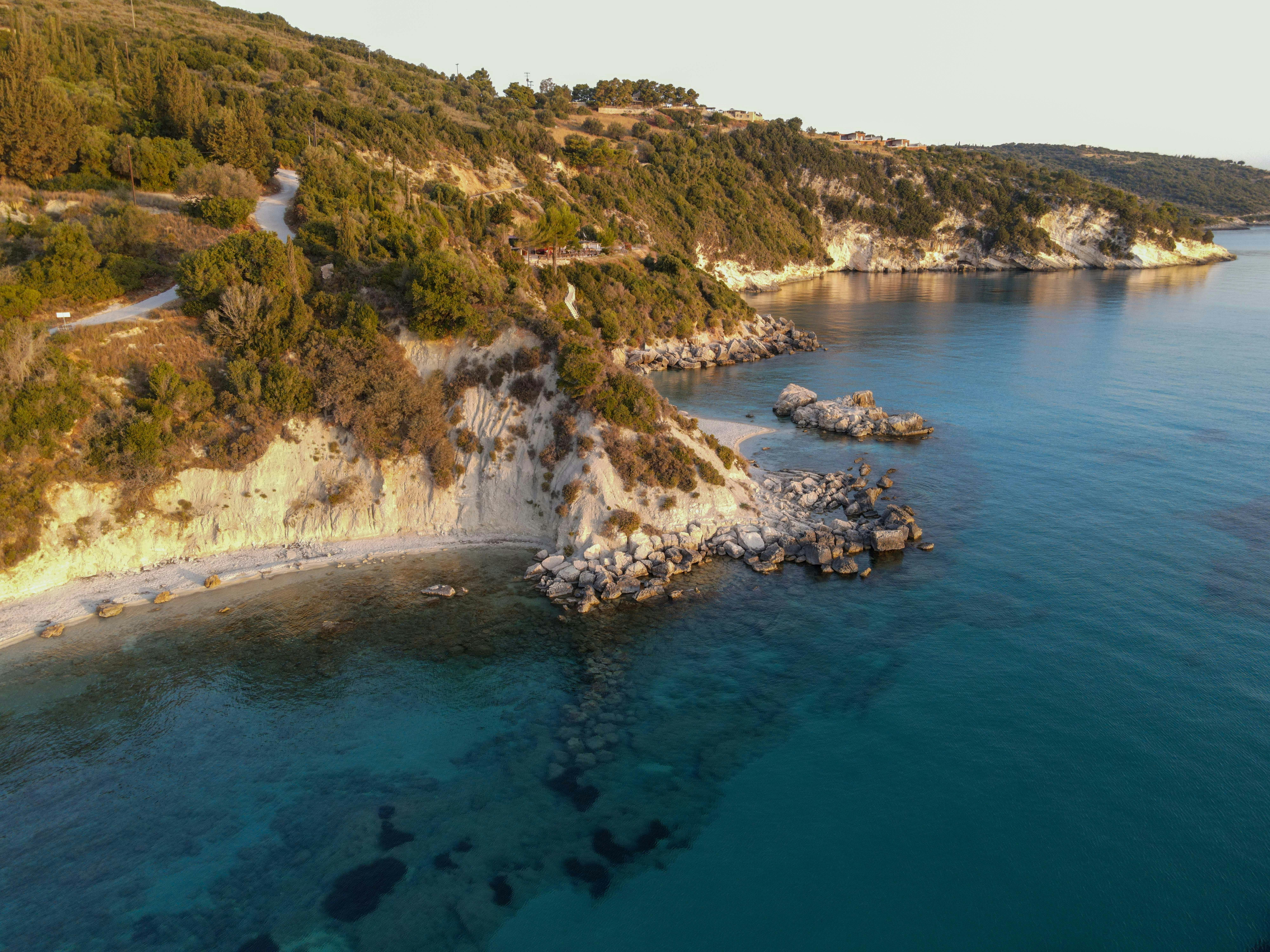 Cliffs meet tranquil waters in a scenic coastal landscape, showcasing rocky formations and lush greenery. Perfectly captures the essence of nature's harmony.