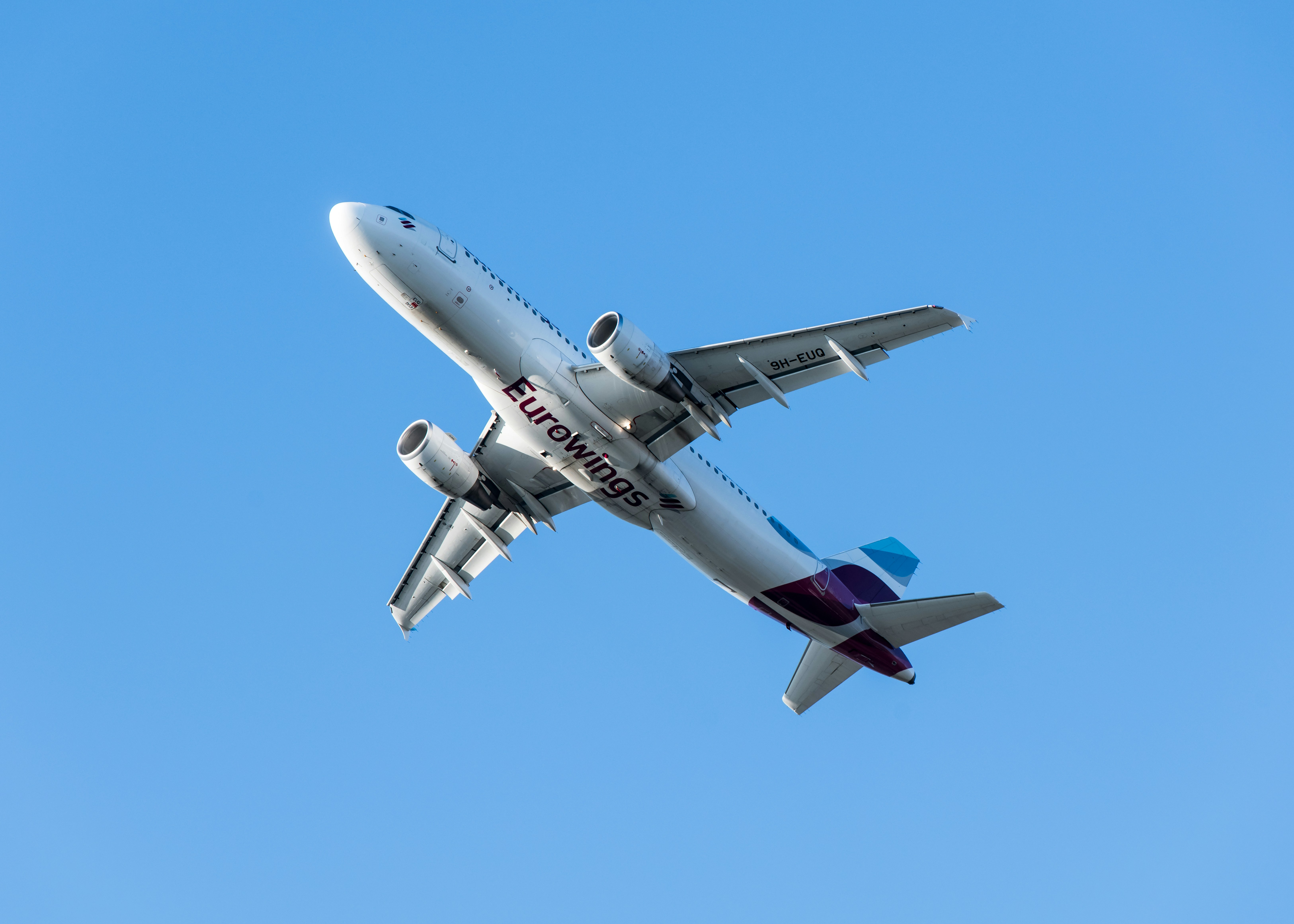 Airplane ascending into a clear blue sky