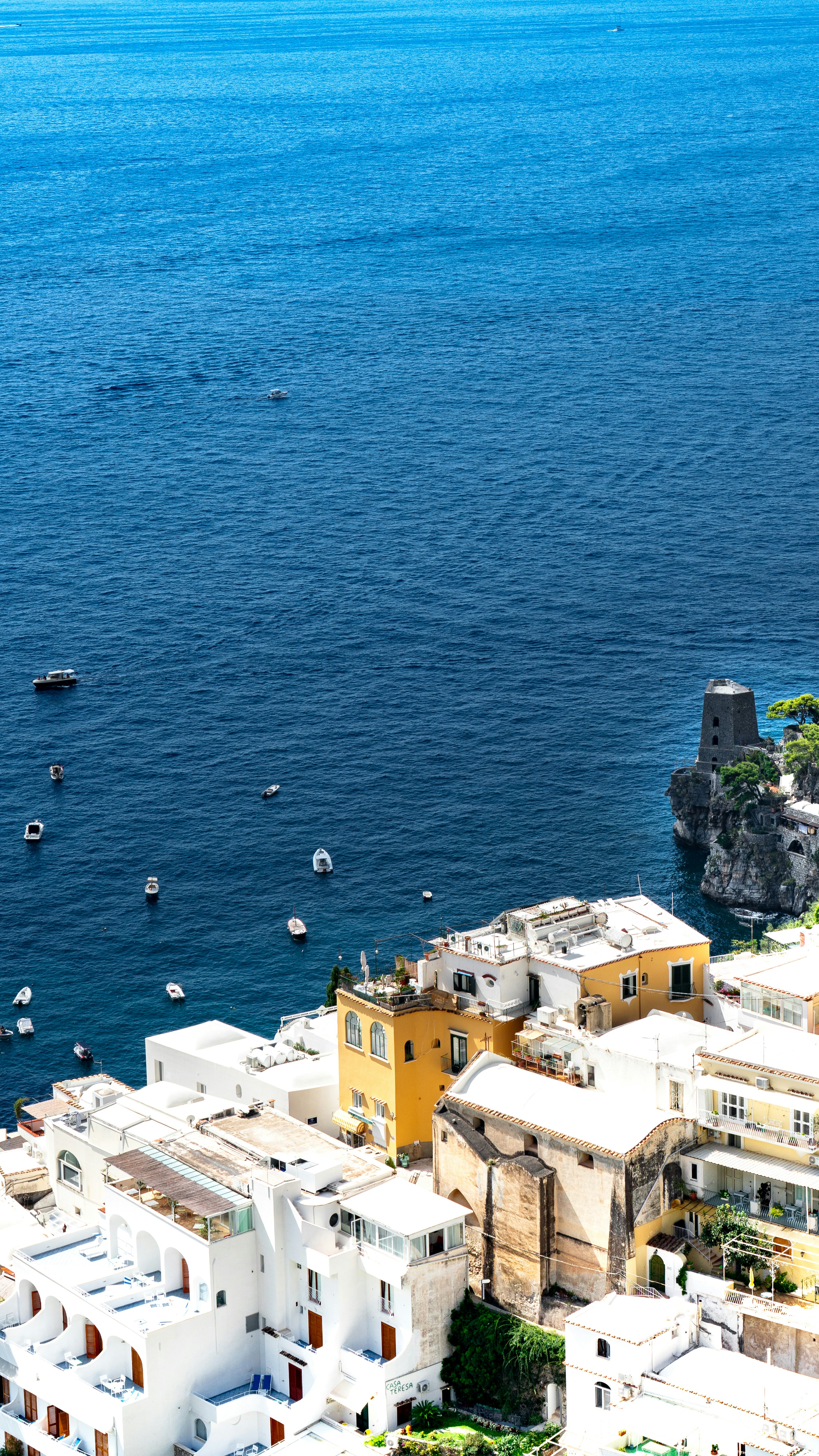 Coastal town with white buildings and blue ocean.