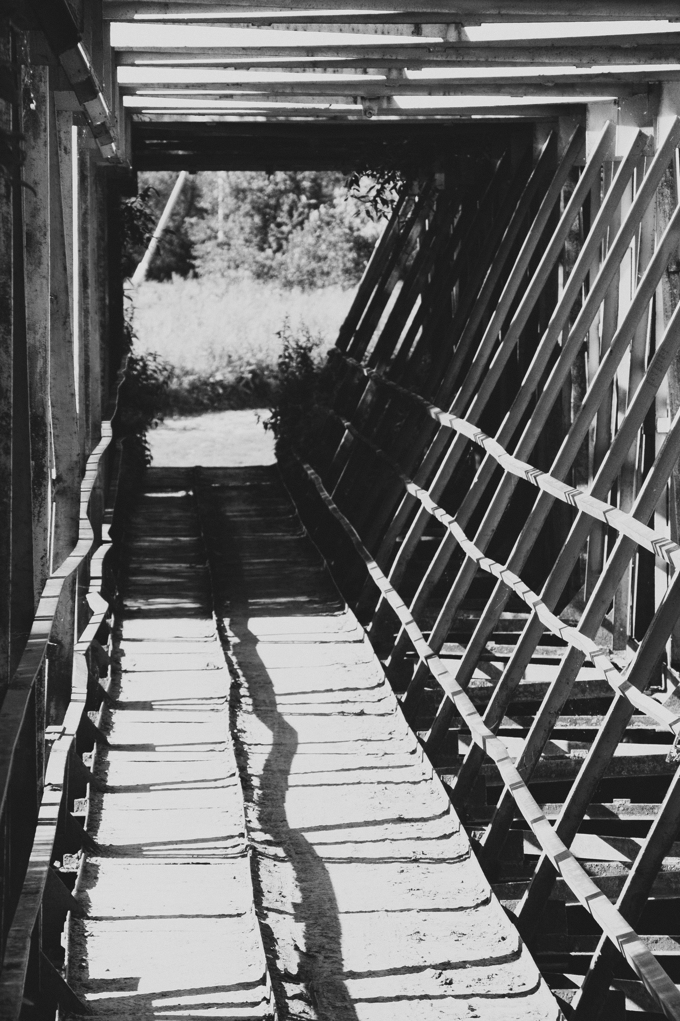 Wooden bridge walkway with diagonal supports and shadows