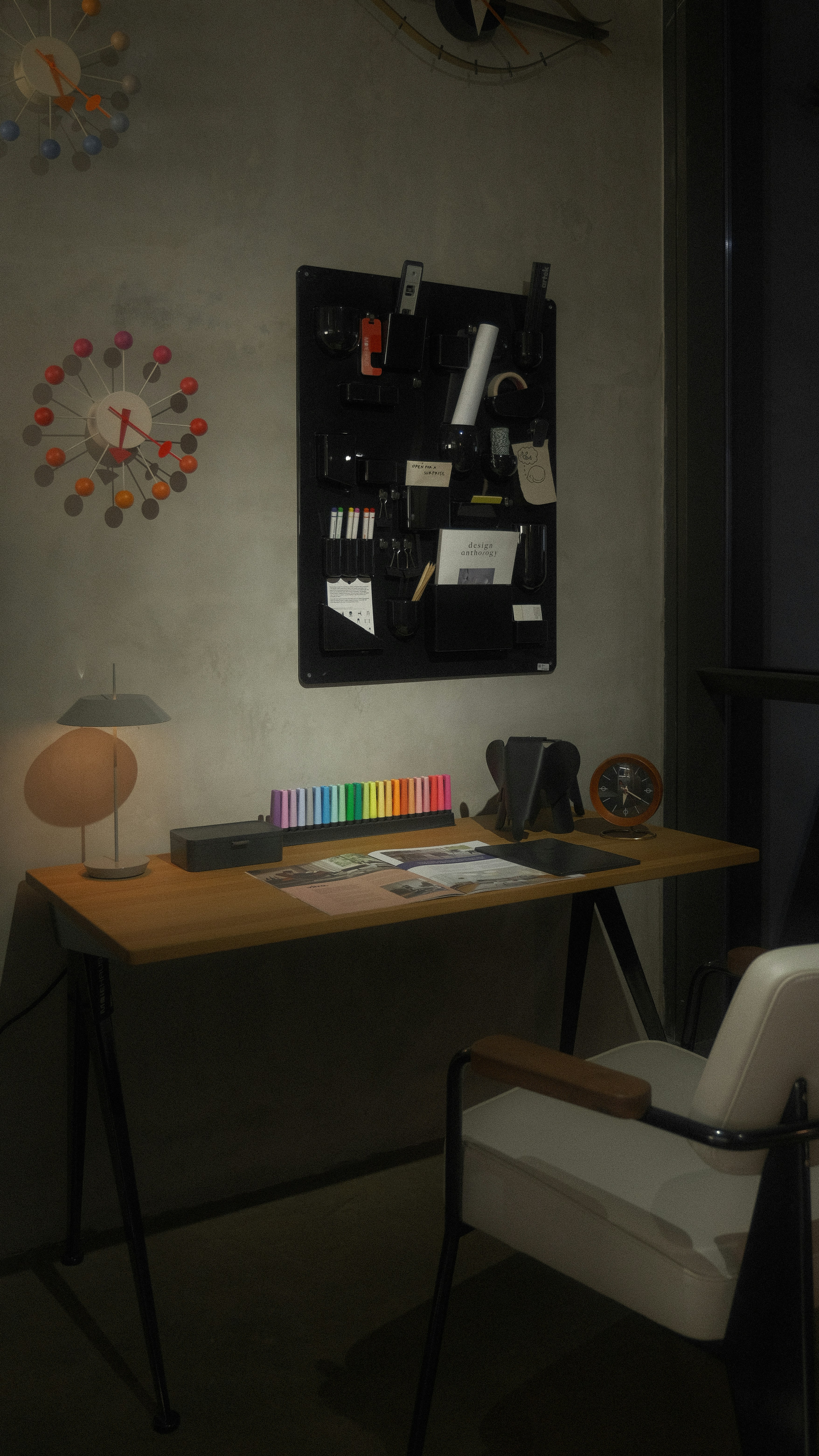 Desk with colorful markers and organized wall board.