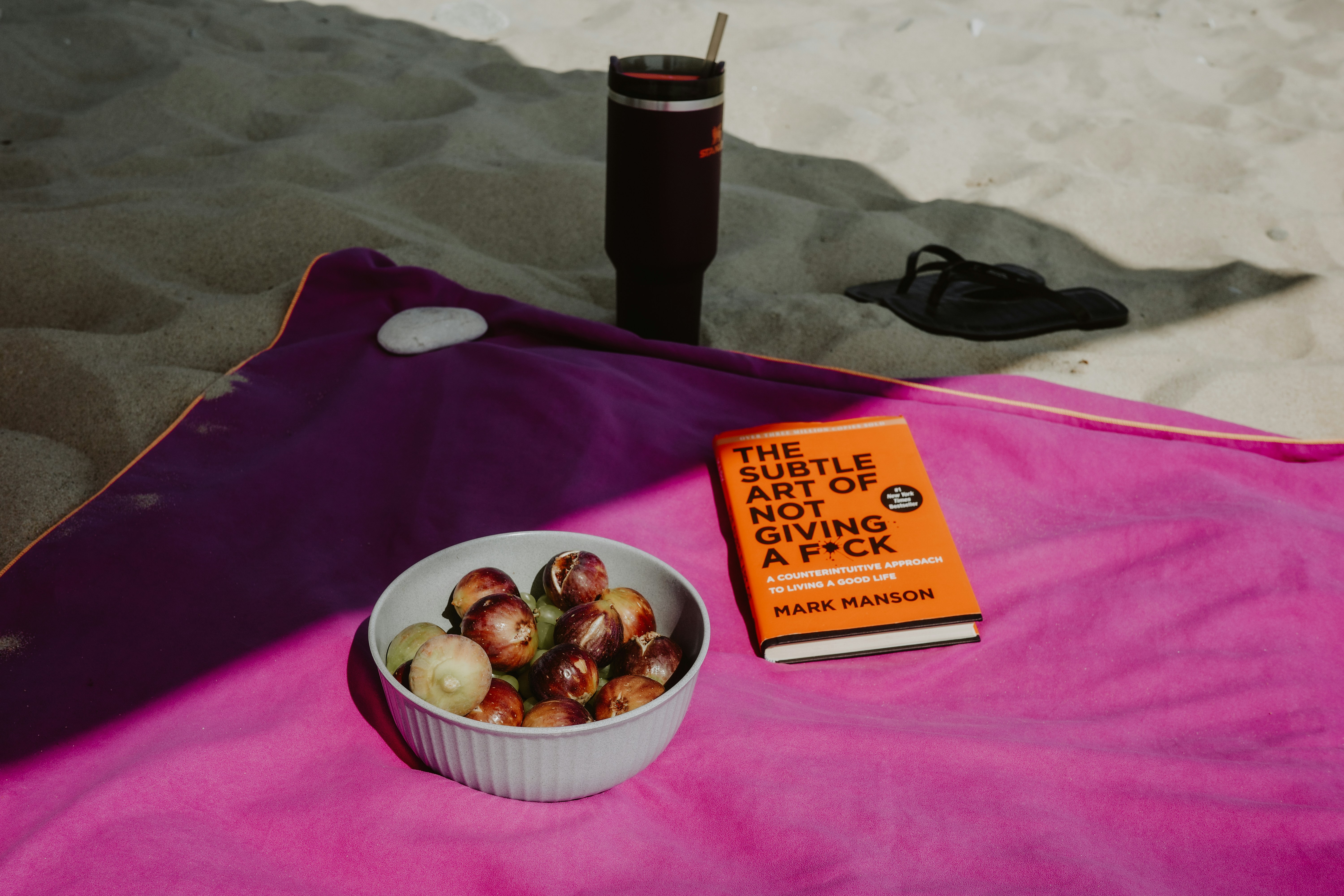 Juicy Treats and a Book on a Pink Beach Towel