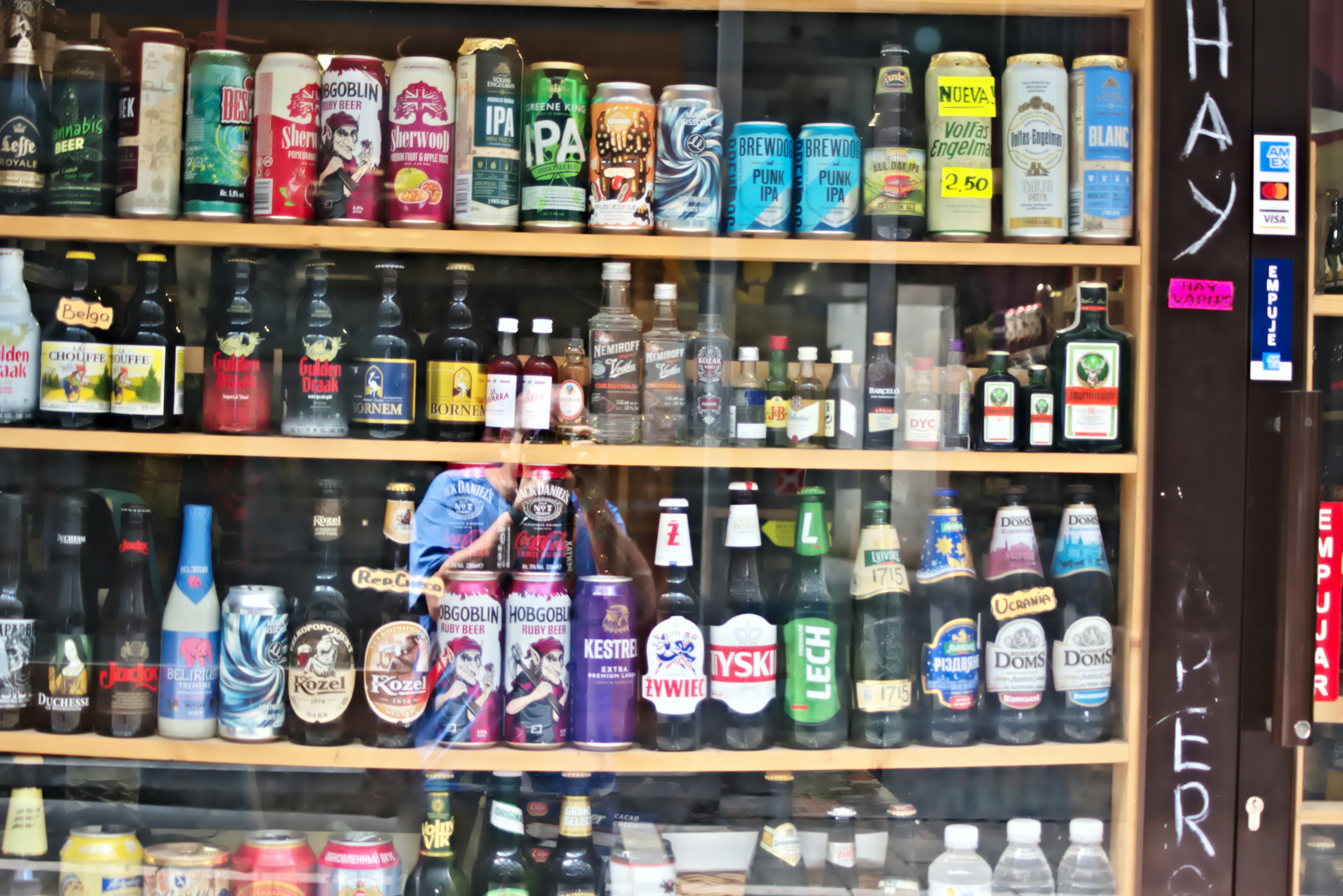 Bull fighting has a long tratition in Pamplona where Peope run in front of the buuls on 7th of July | Shelves filled with assorted bottles and cans of drinks.