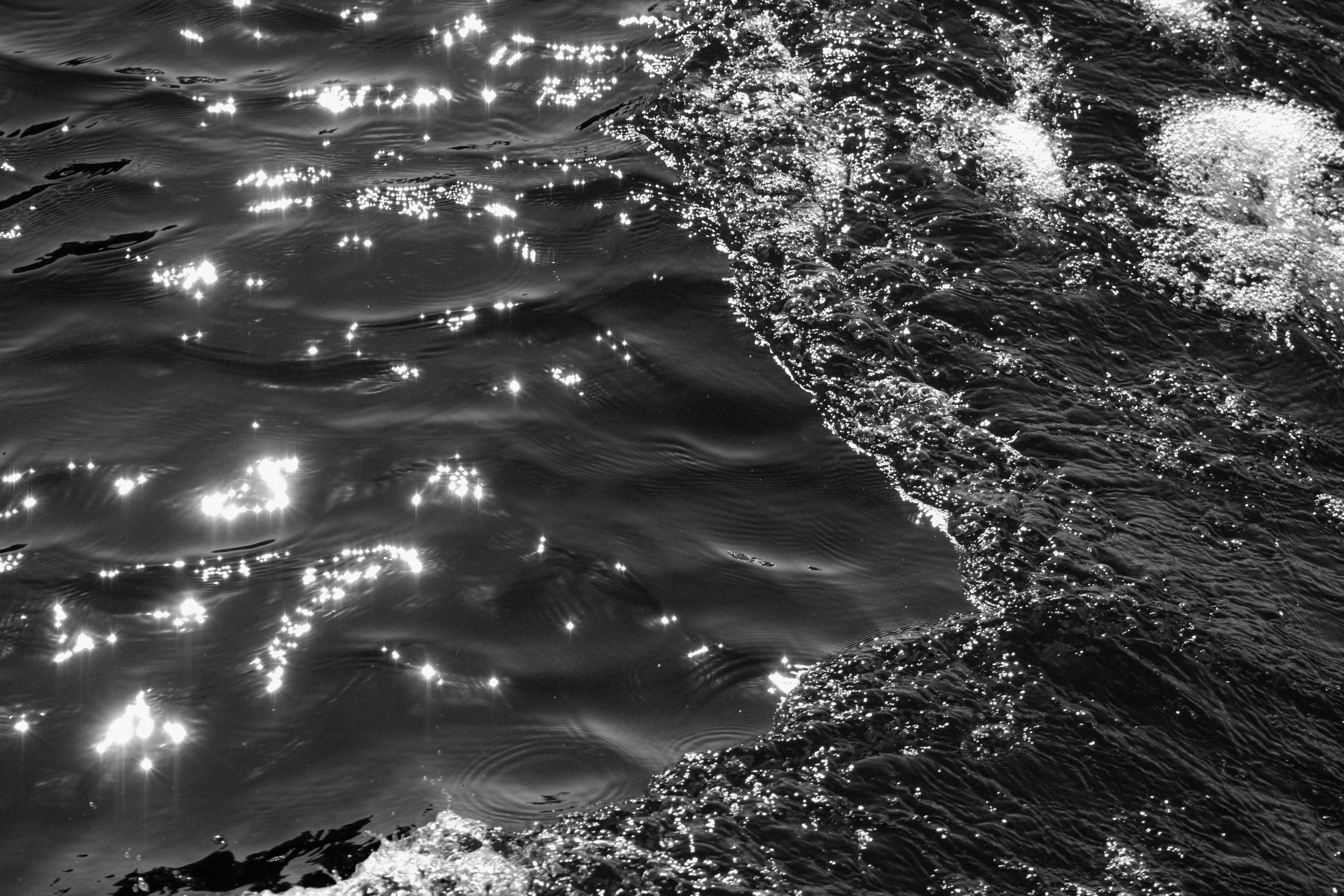 black and white water splashing in deep lake | Sparkling water surface with waves and foam