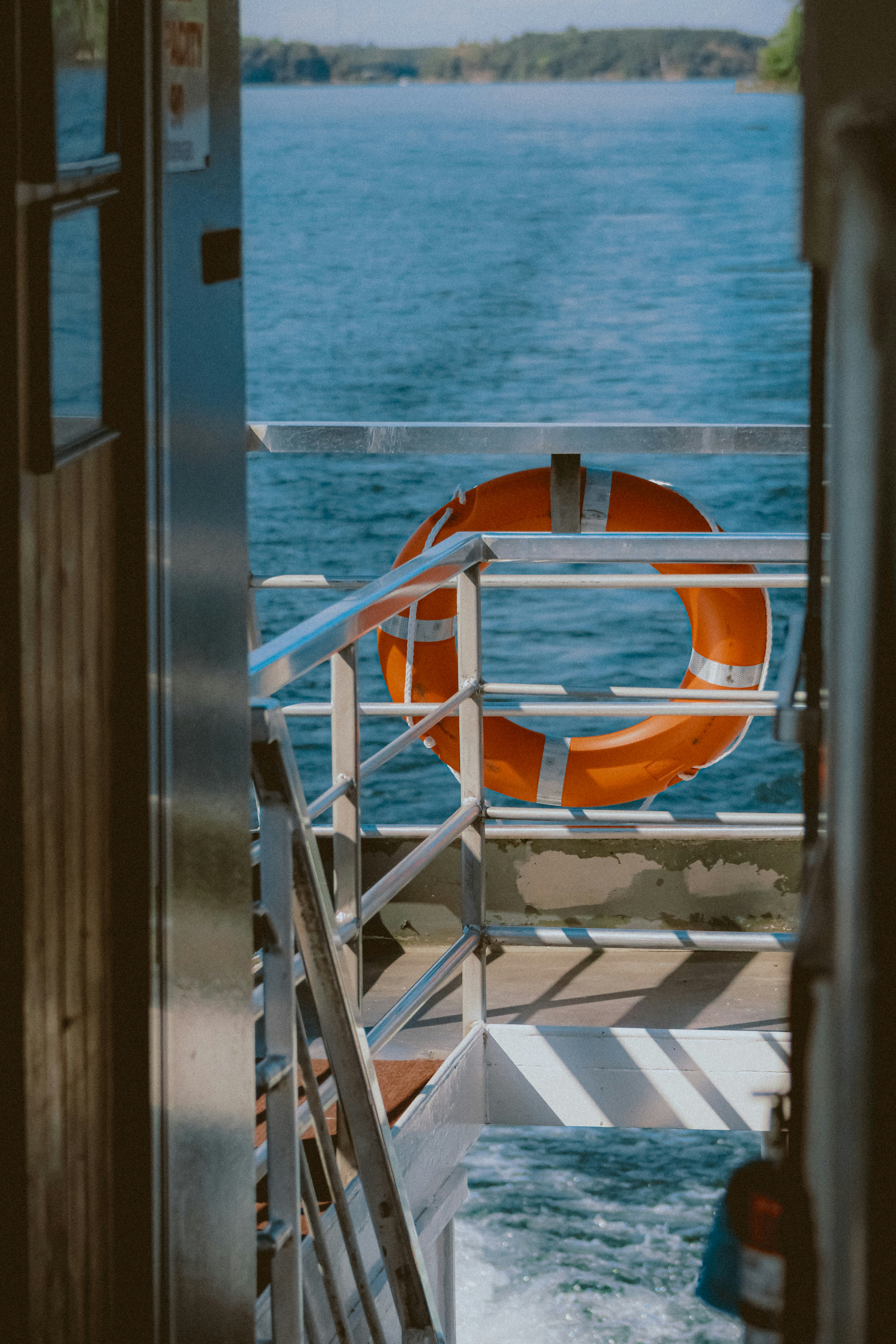 Orange life preserver on a boat railing over water photo – Free Image ...