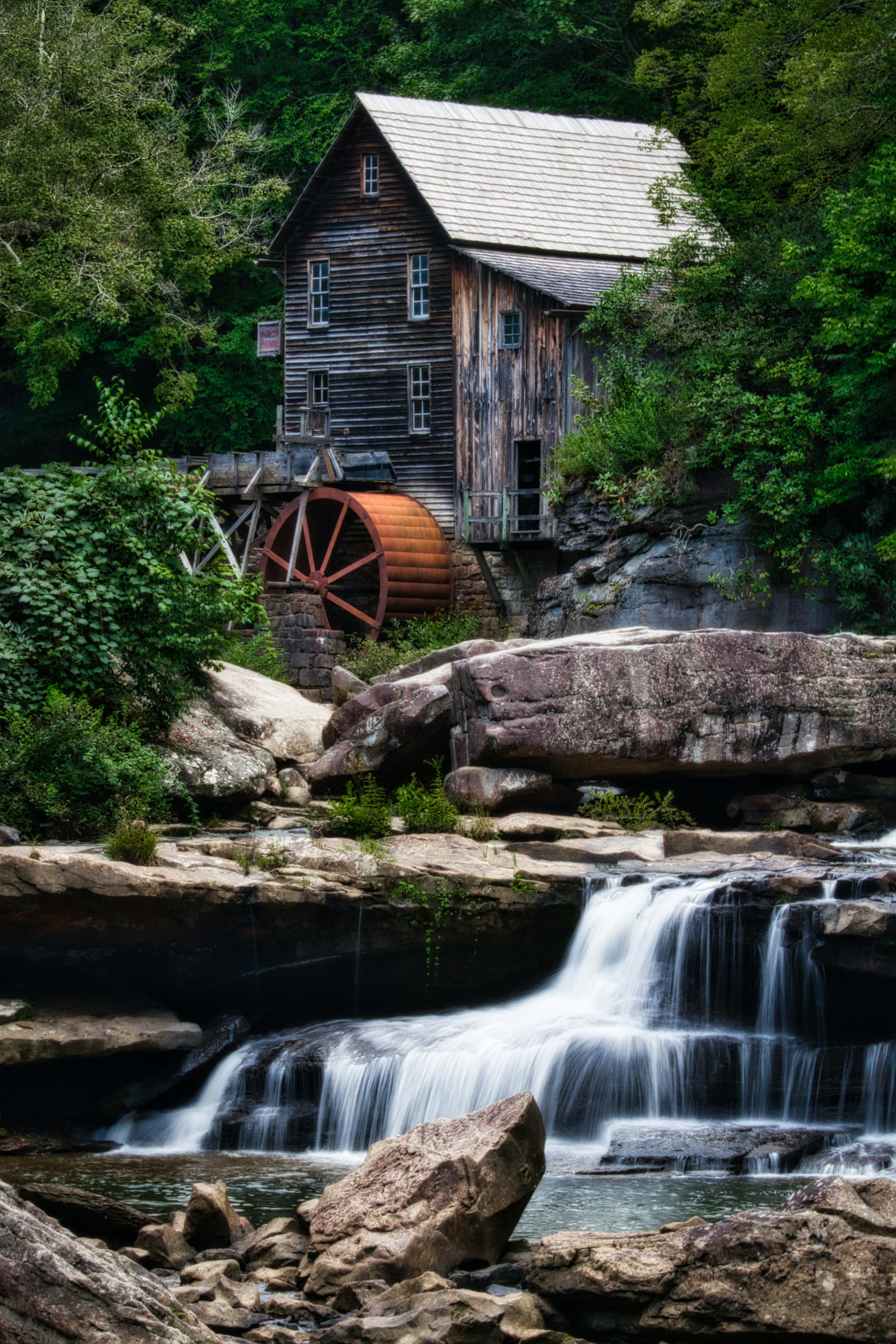 Grist Mill Babcock State Park, West Virginia | Rustic wooden mill with water wheel beside waterfall.