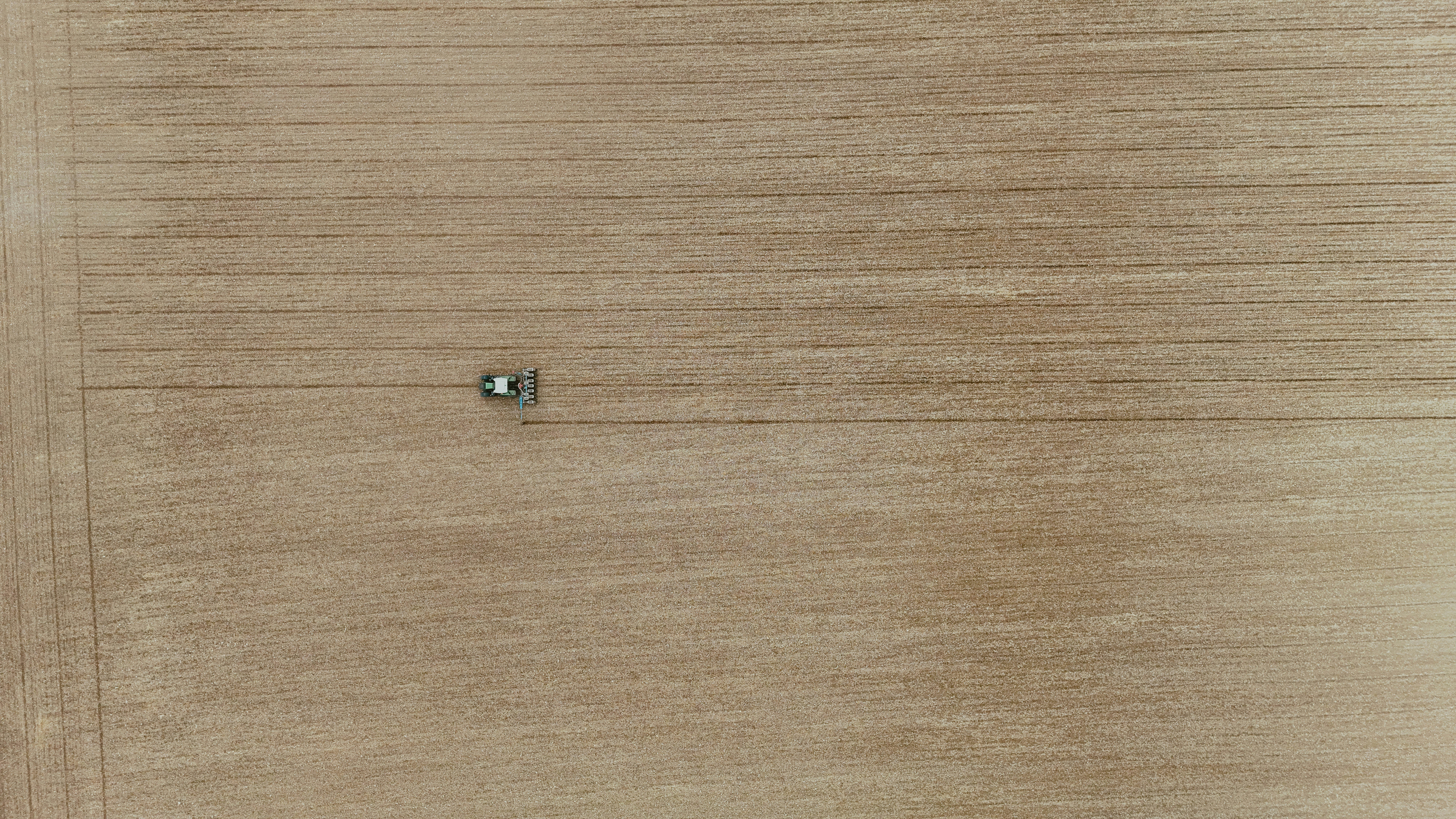 Aerial view of a tractor plowing a large field