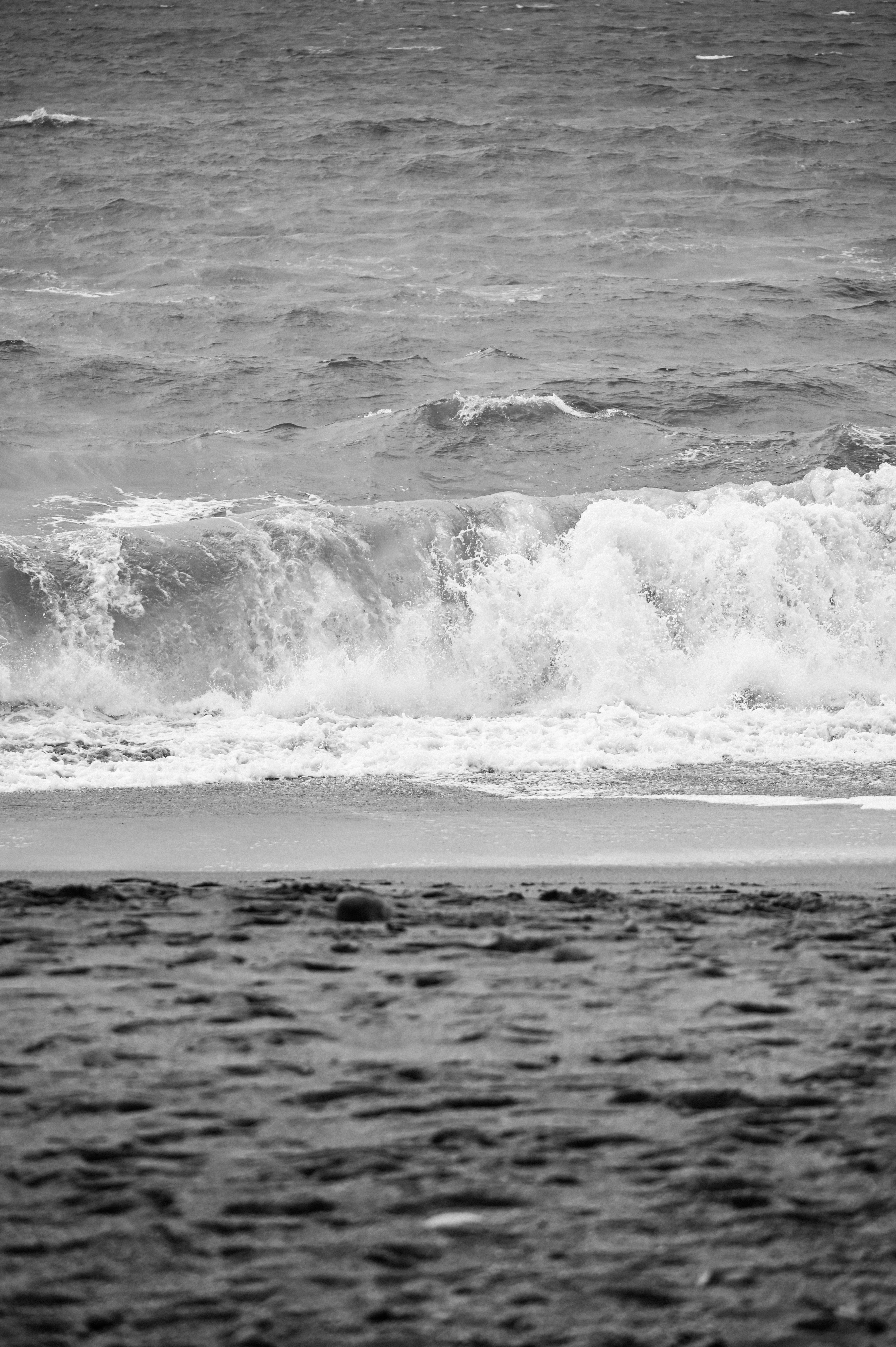 West Bay bnw | Waves crashing on a sandy beach in black and white.