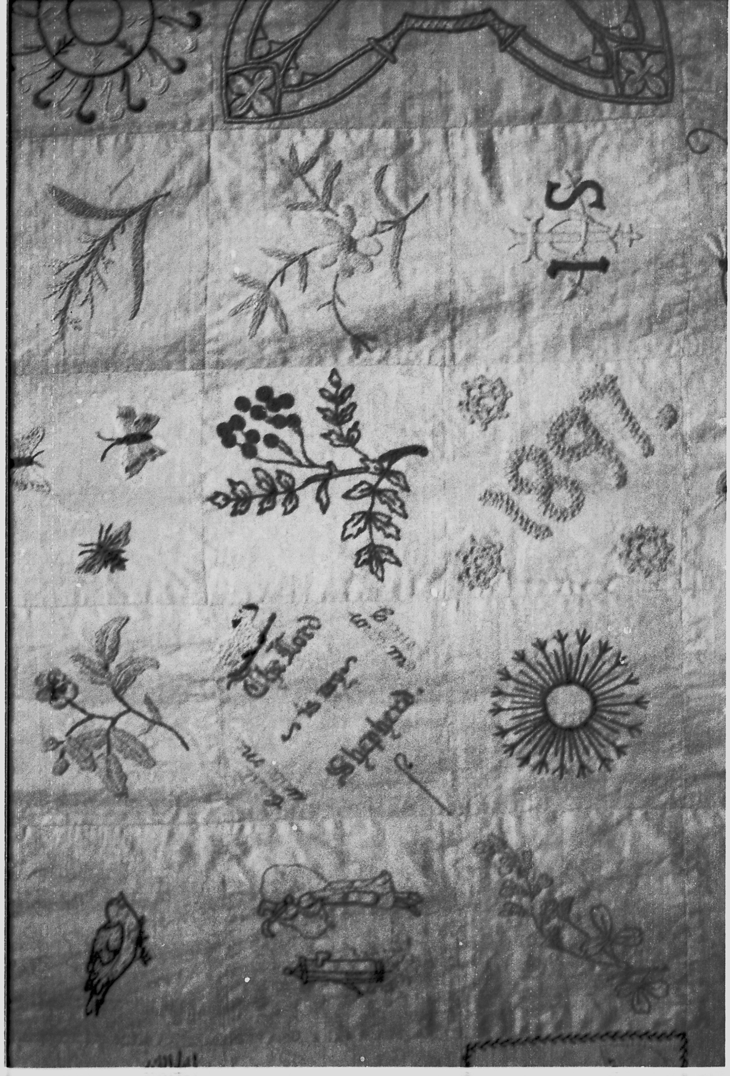 Intricate embroidery on fabric showcasing floral motifs and the year 1897, reflecting craftsmanship and historical artistry.