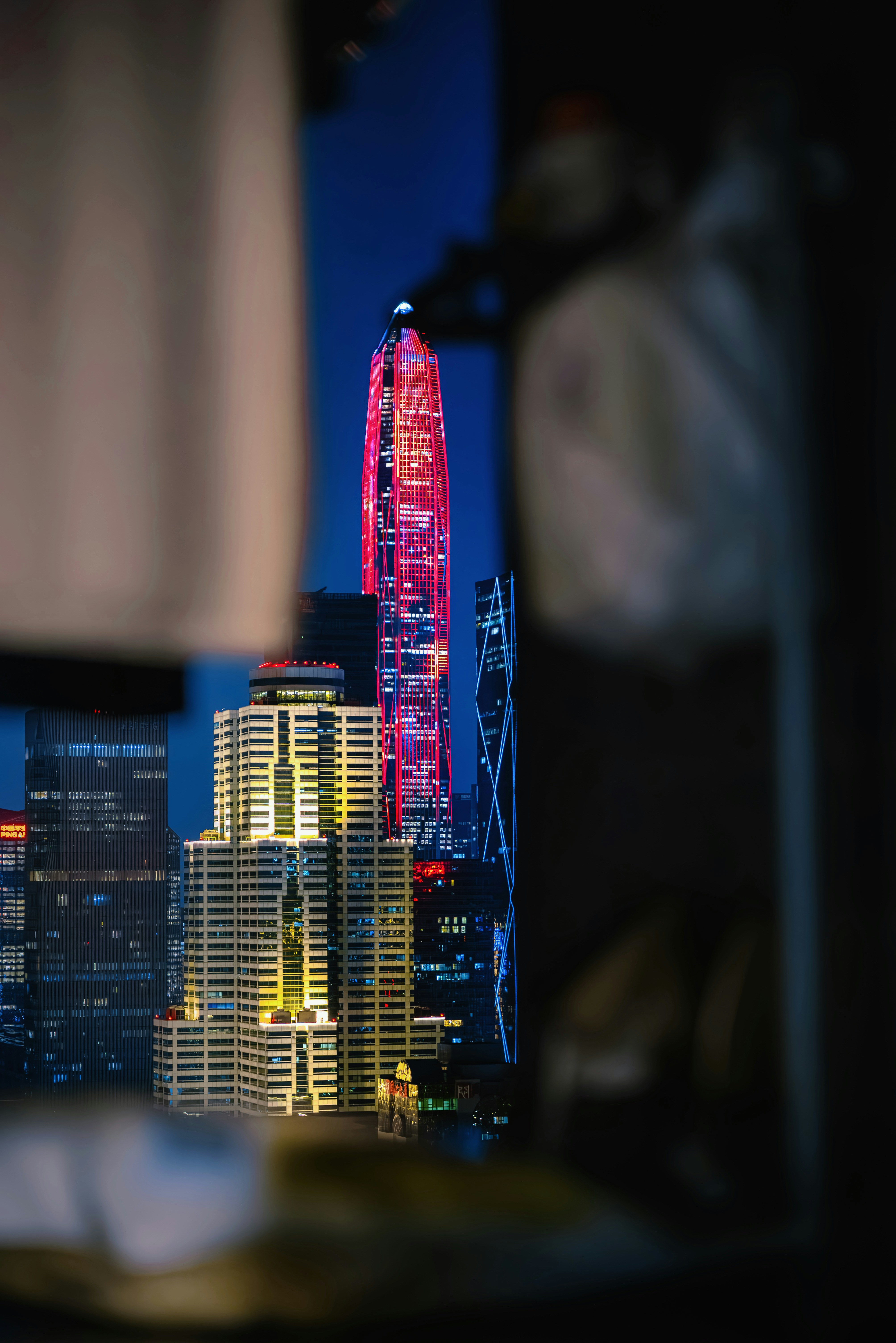 Crimson Spire Pierces a Framed Neon Nightscape
