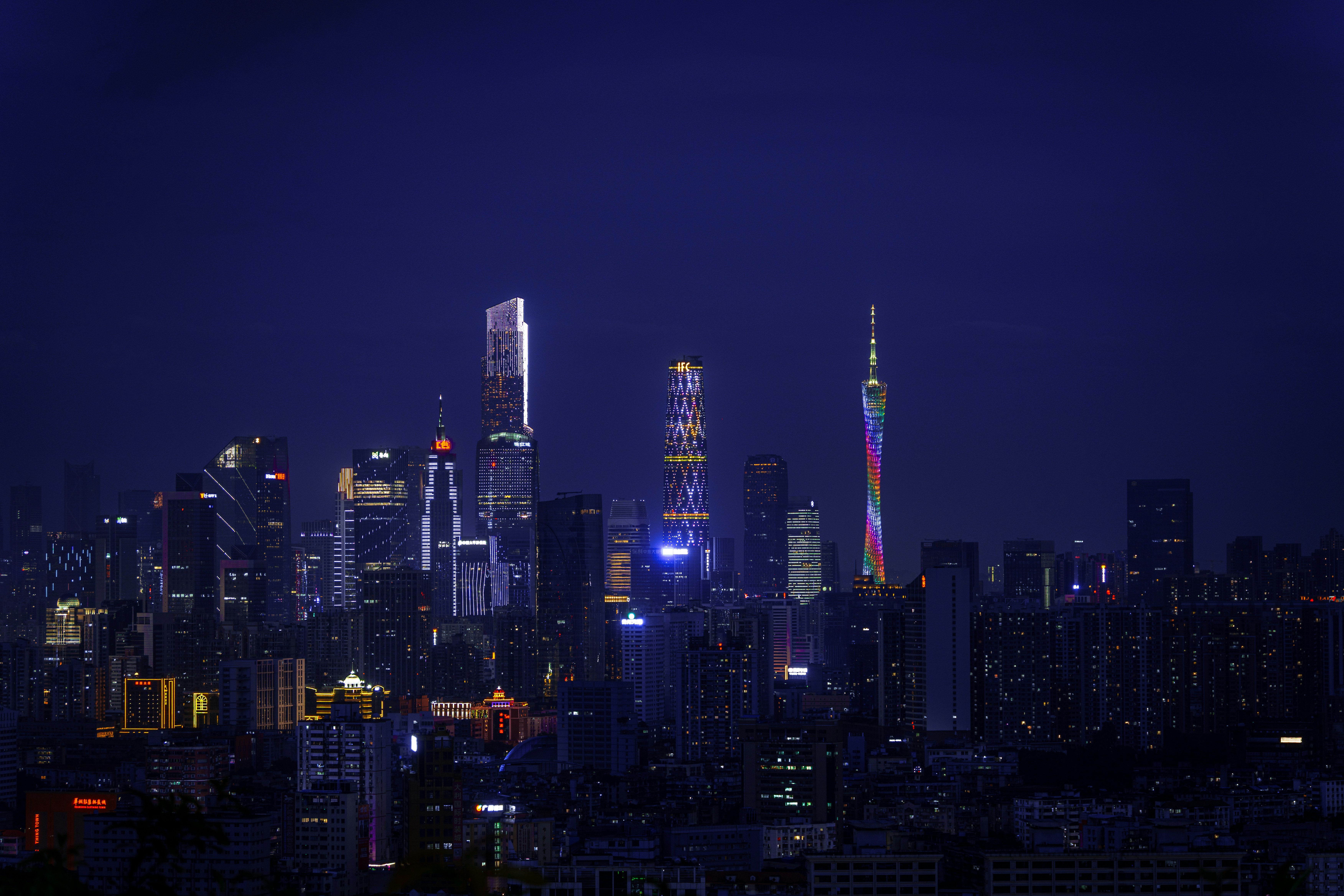 Illuminated skyline of a bustling city at night, showcasing modern architecture and vibrant lights.