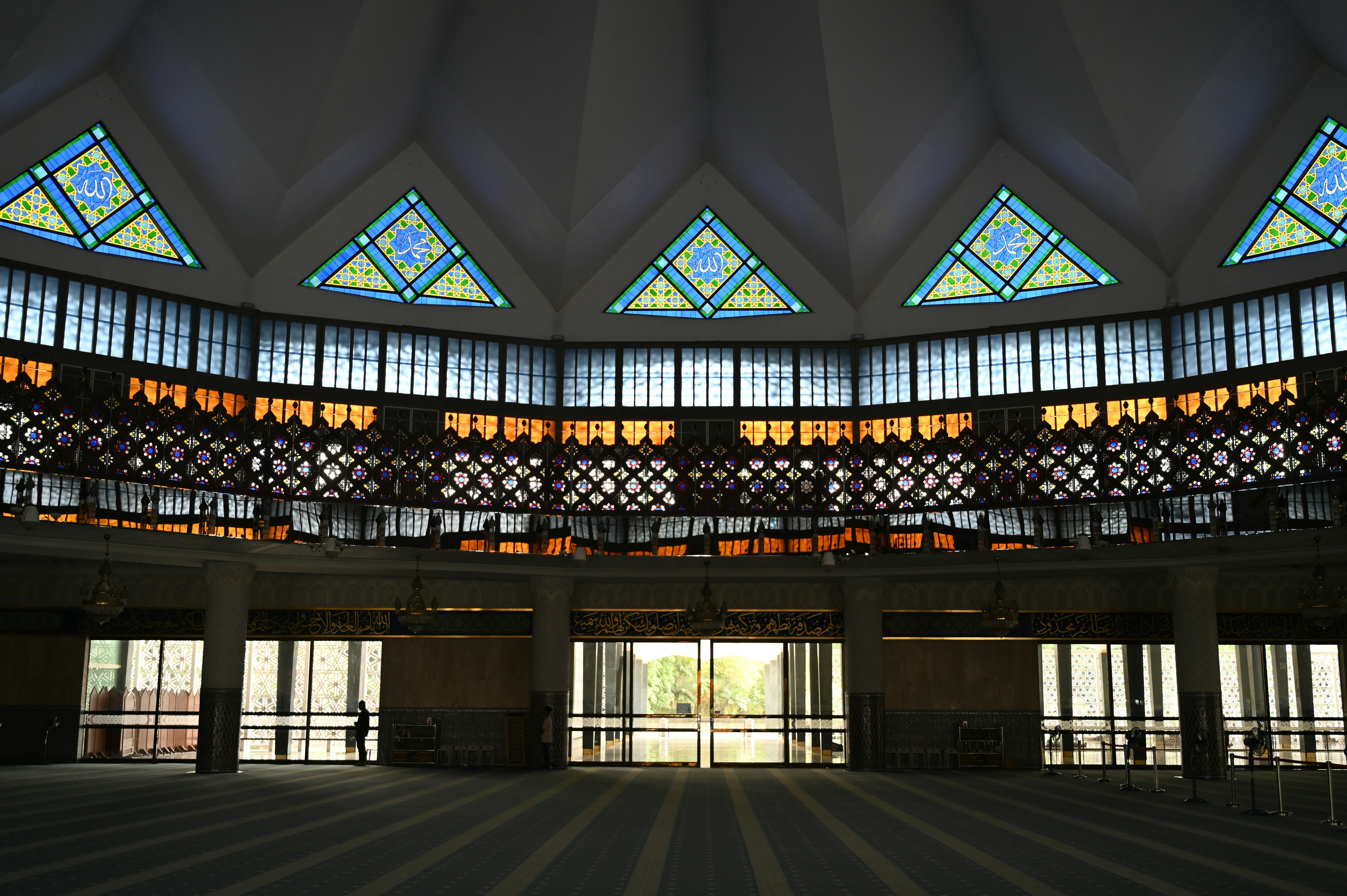 Interior view of a modern mosque with geometric windows.