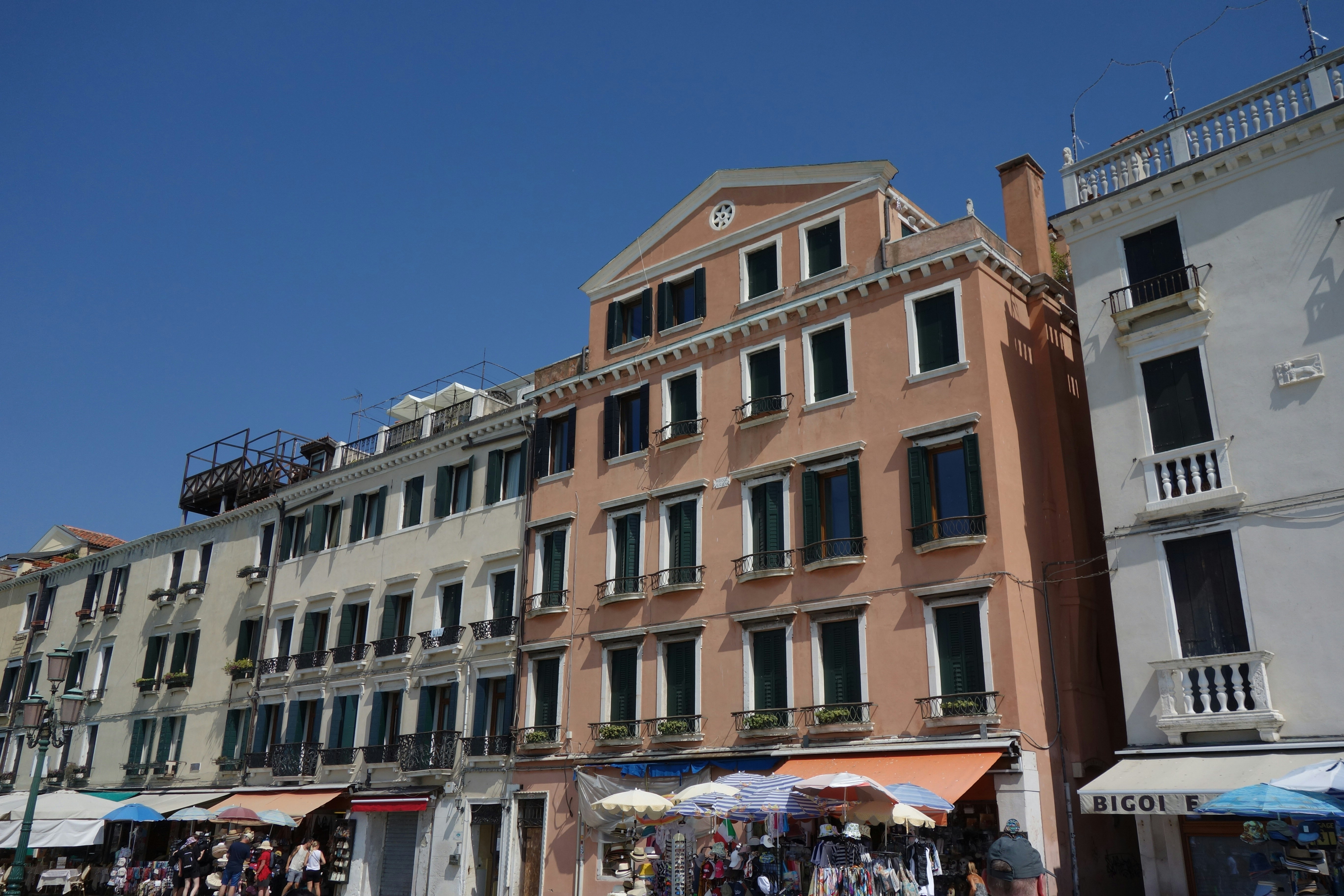 Tall buildings with shops on the ground floor.