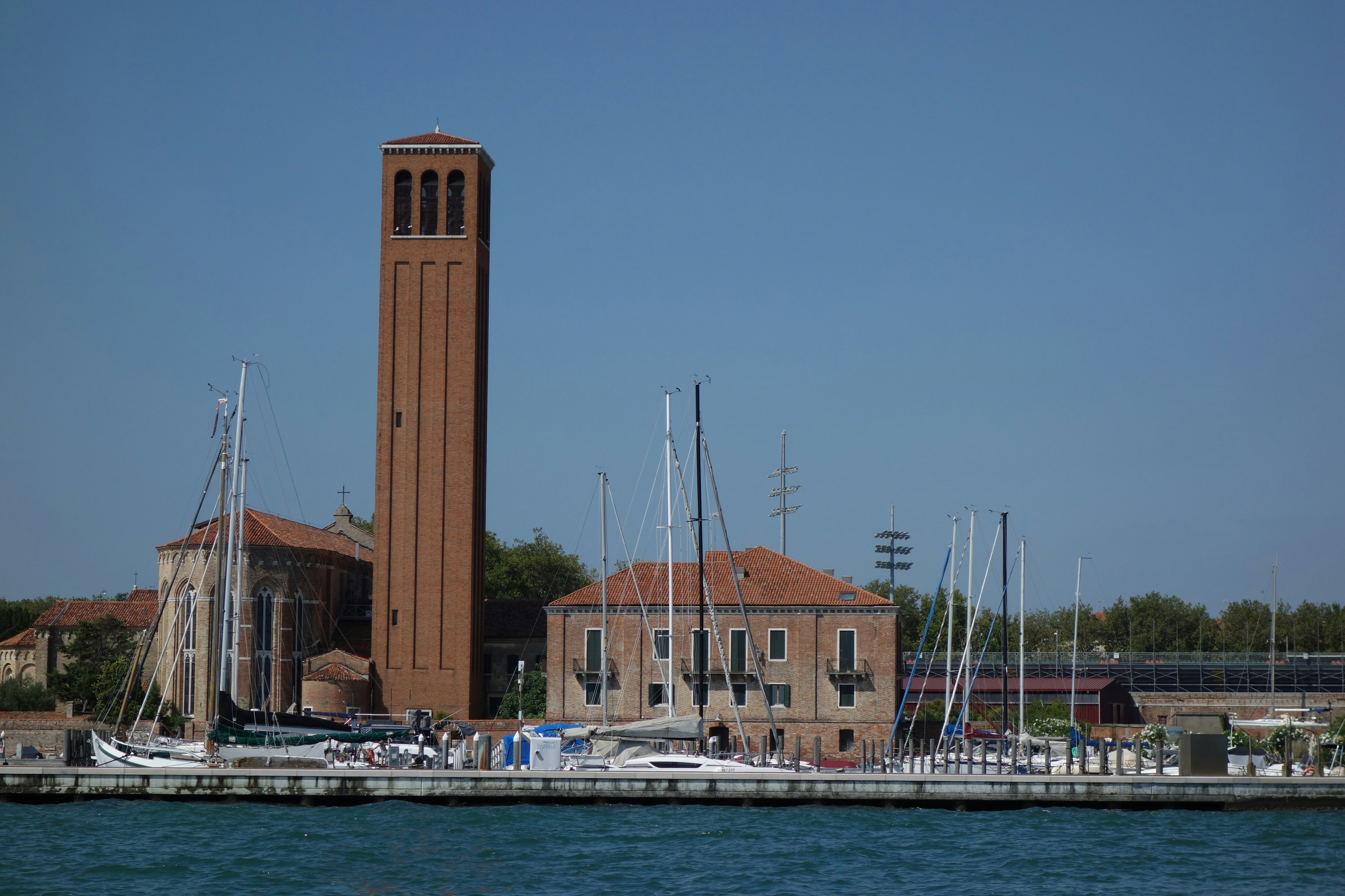 Tall brick tower with boats docked nearby