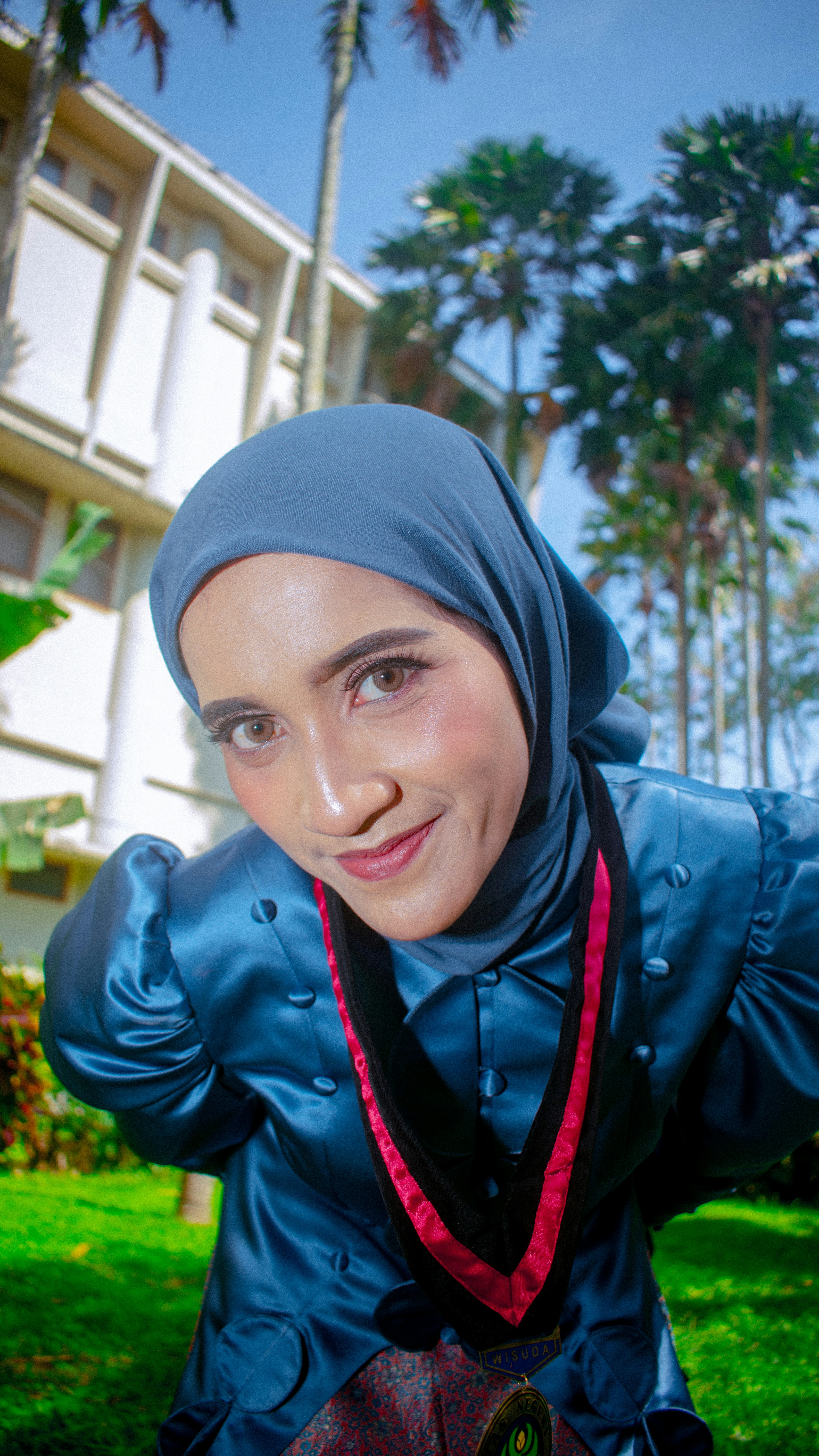 Blue Hijab Portrait Amid Palm Trees and Sunlit Courtyard