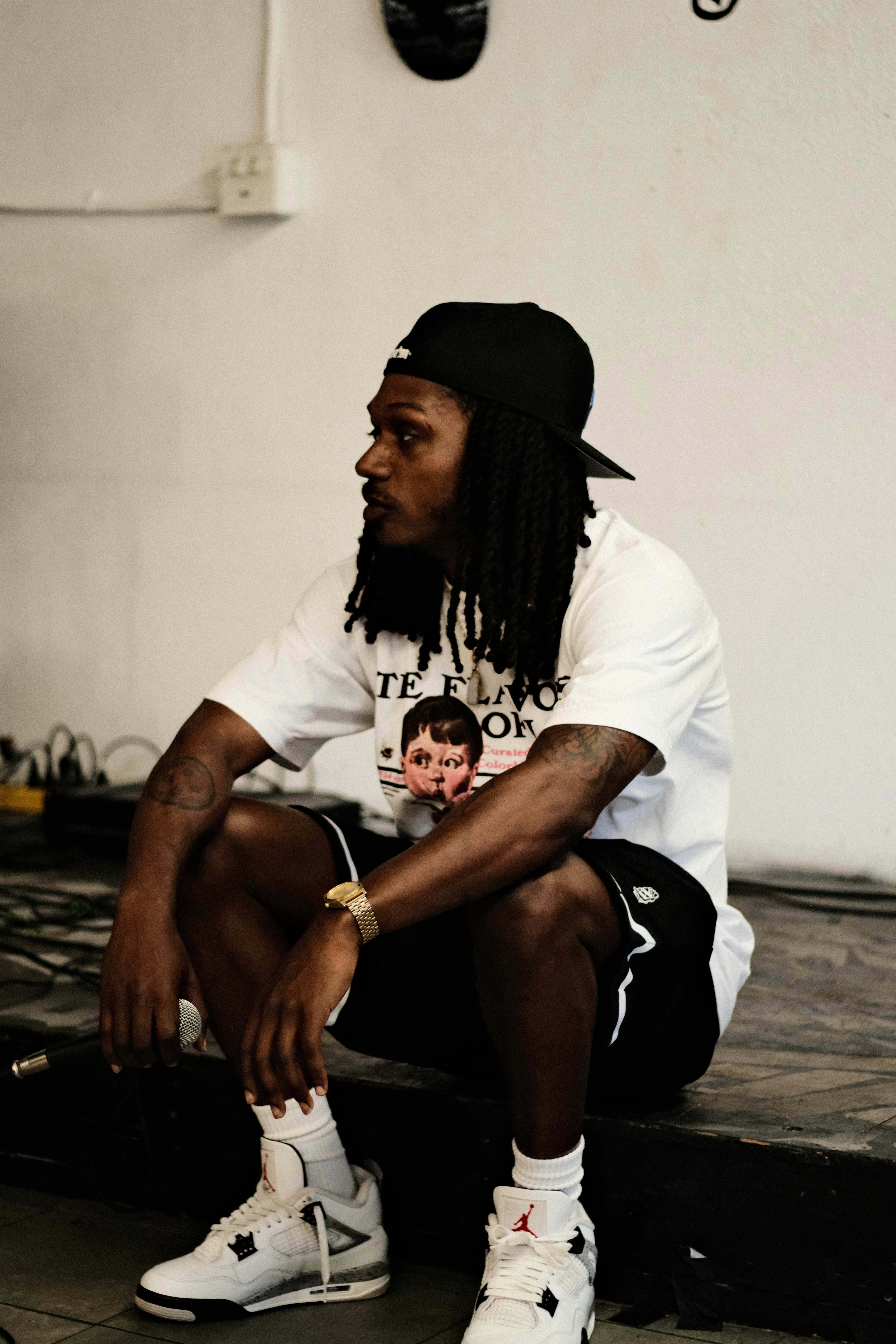 Solitary Moment: A rapper sits on the edge of a stage in contemplation