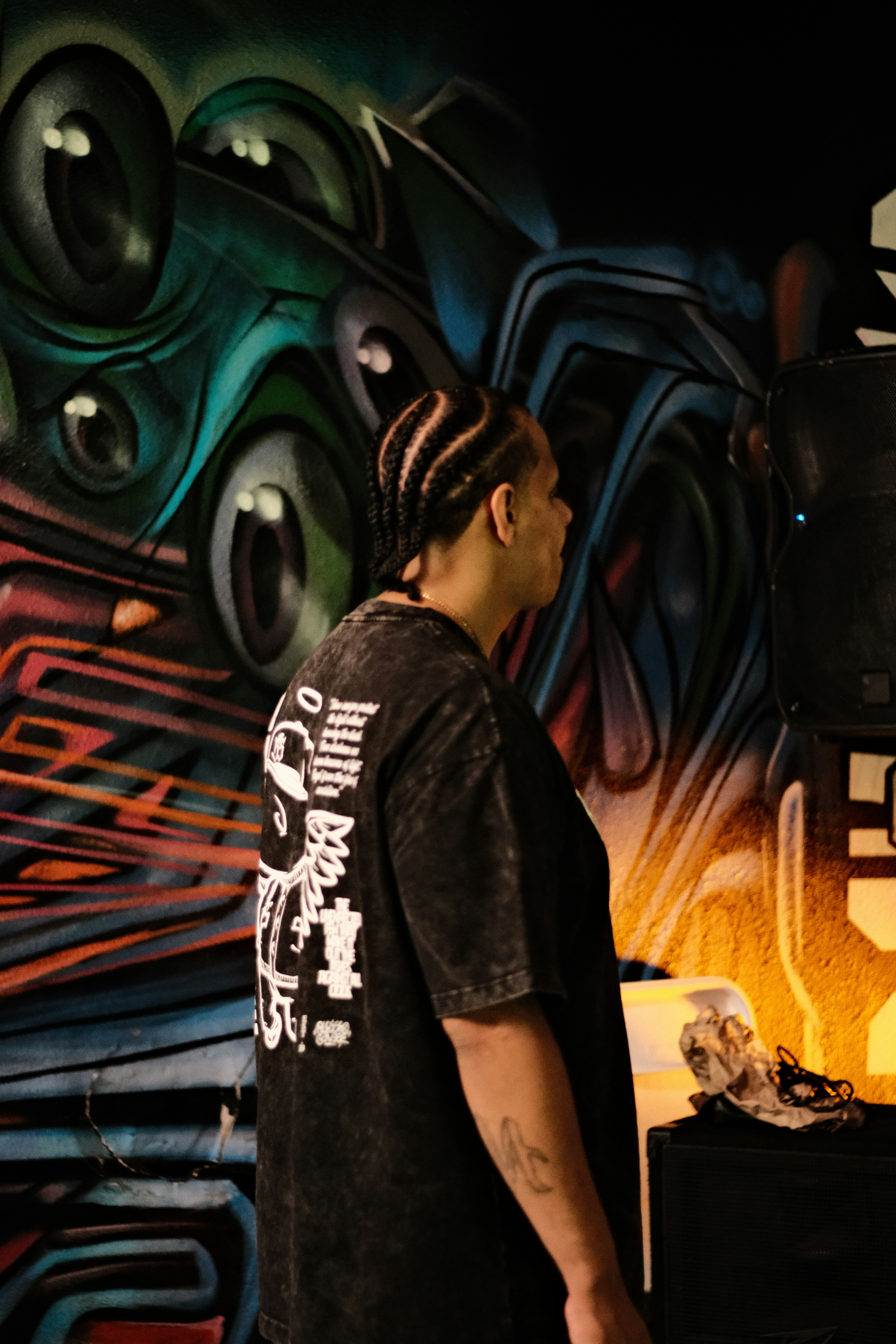 Person stands before abstract graffiti art