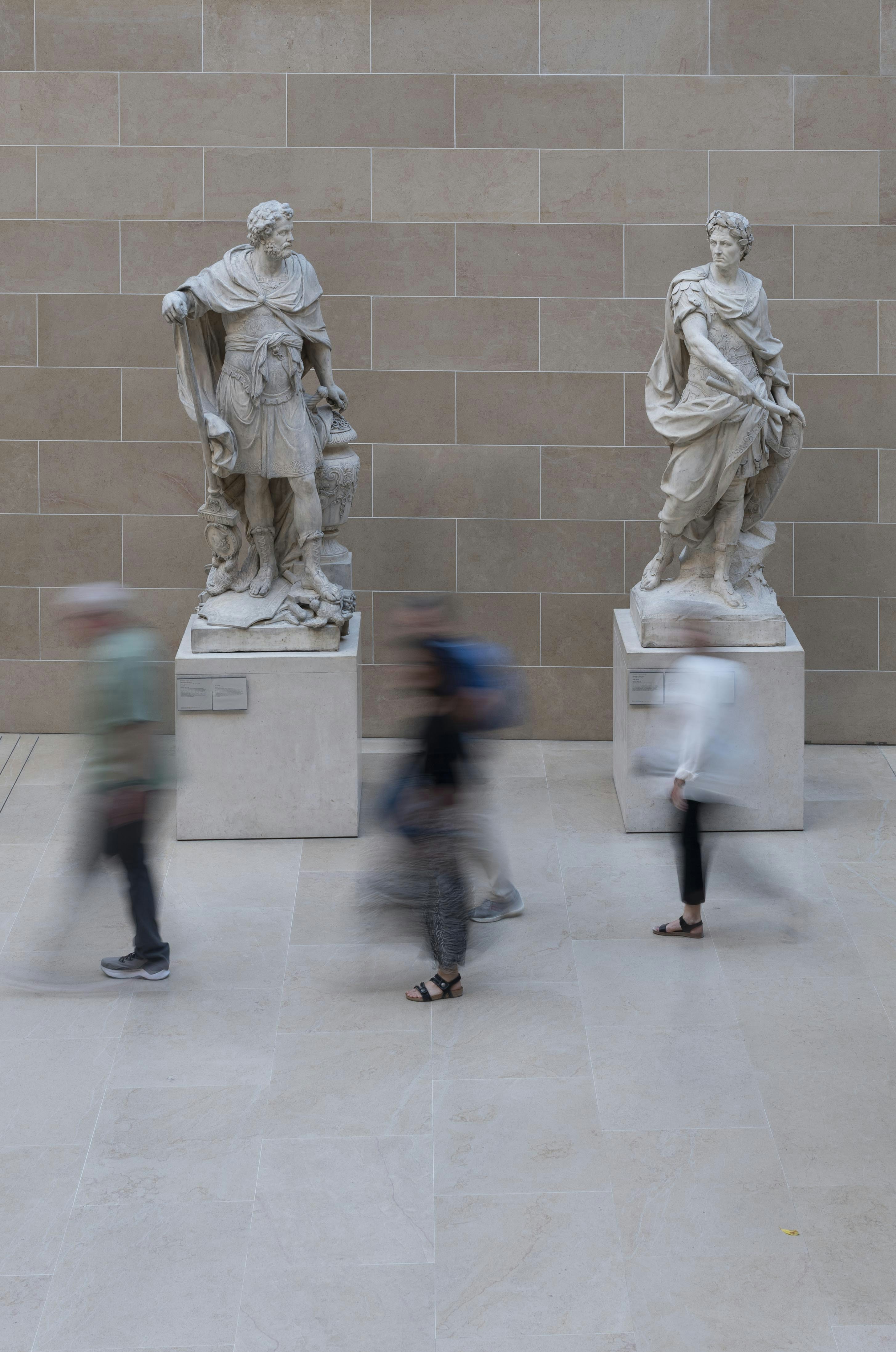 Marble Guardians Between Moving Passersby