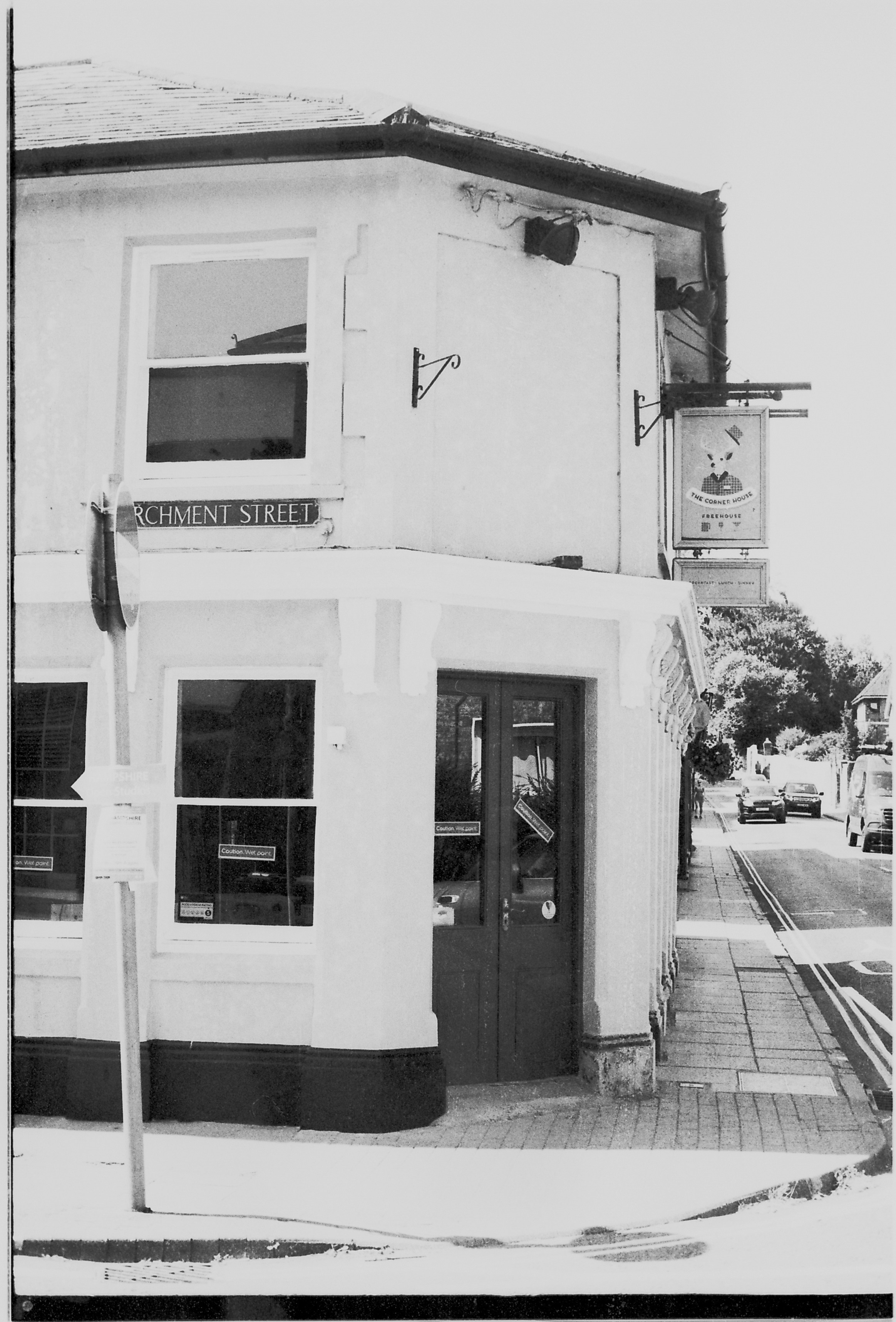 Corner building with windows and a pub sign.
