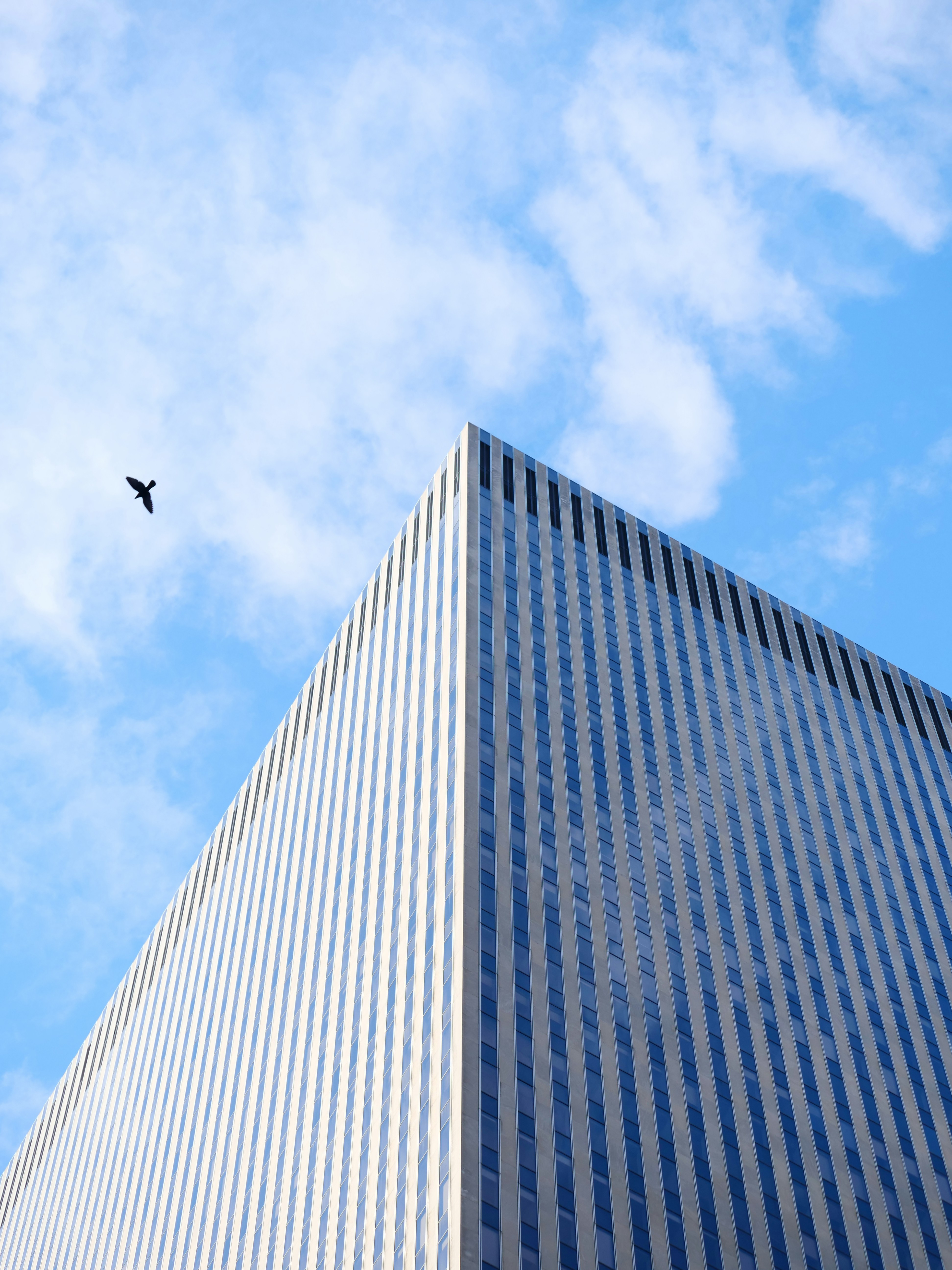 Modern skyscraper corner against a blue sky.