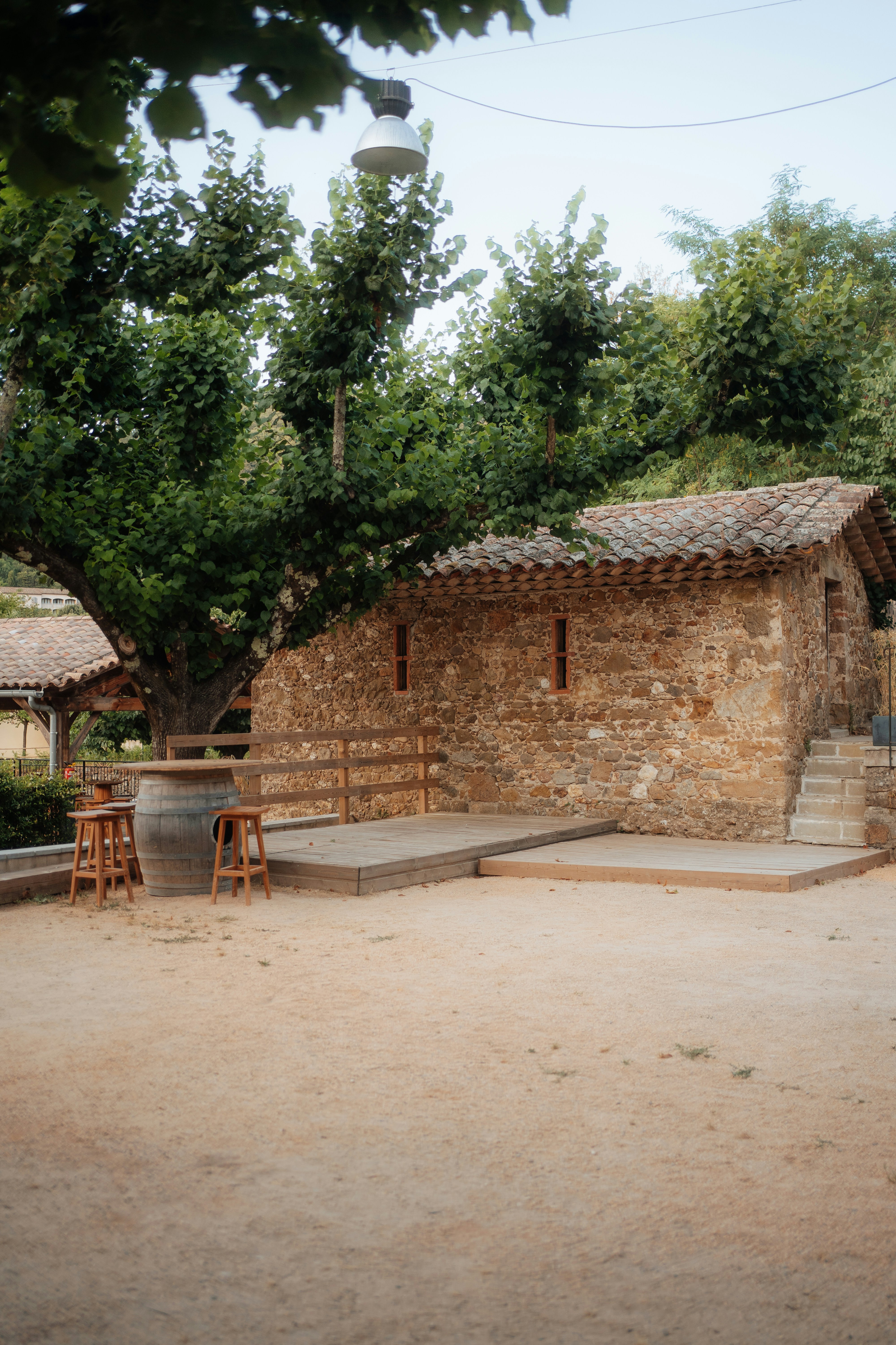 Stone building with wooden barrel and stools outside