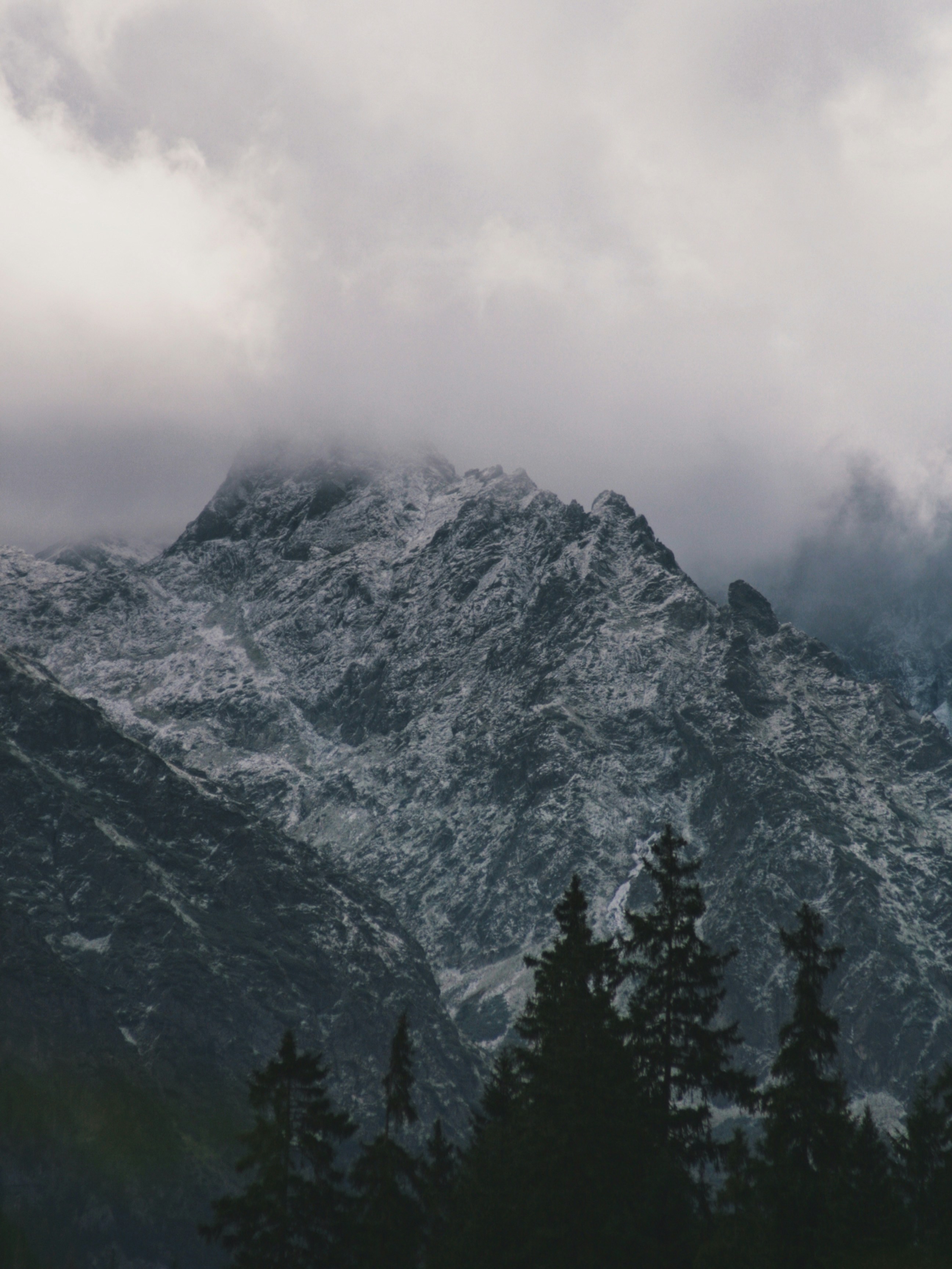 Snow-covered mountain peak shrouded in clouds
