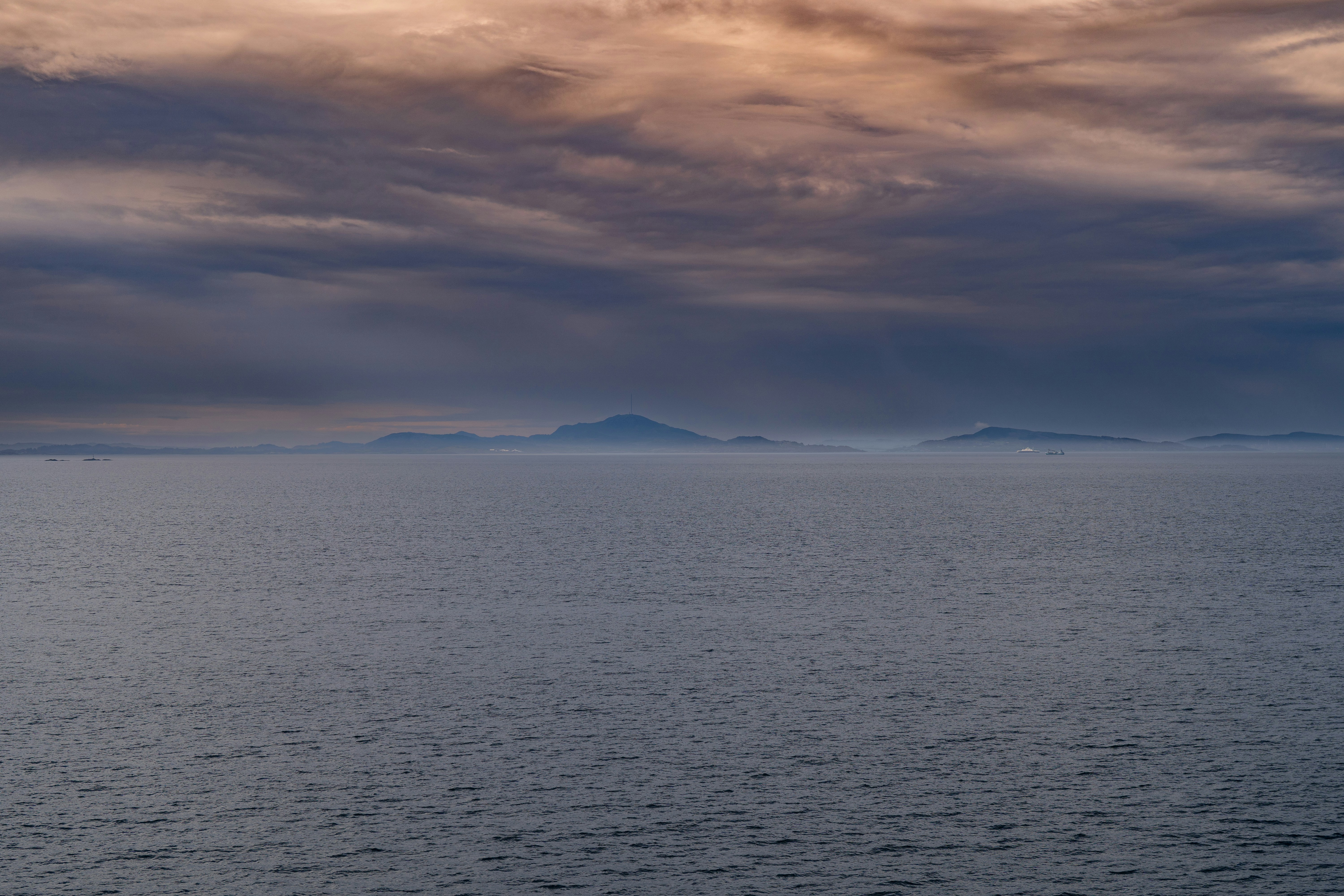 Distant islands under a cloudy sky at sea