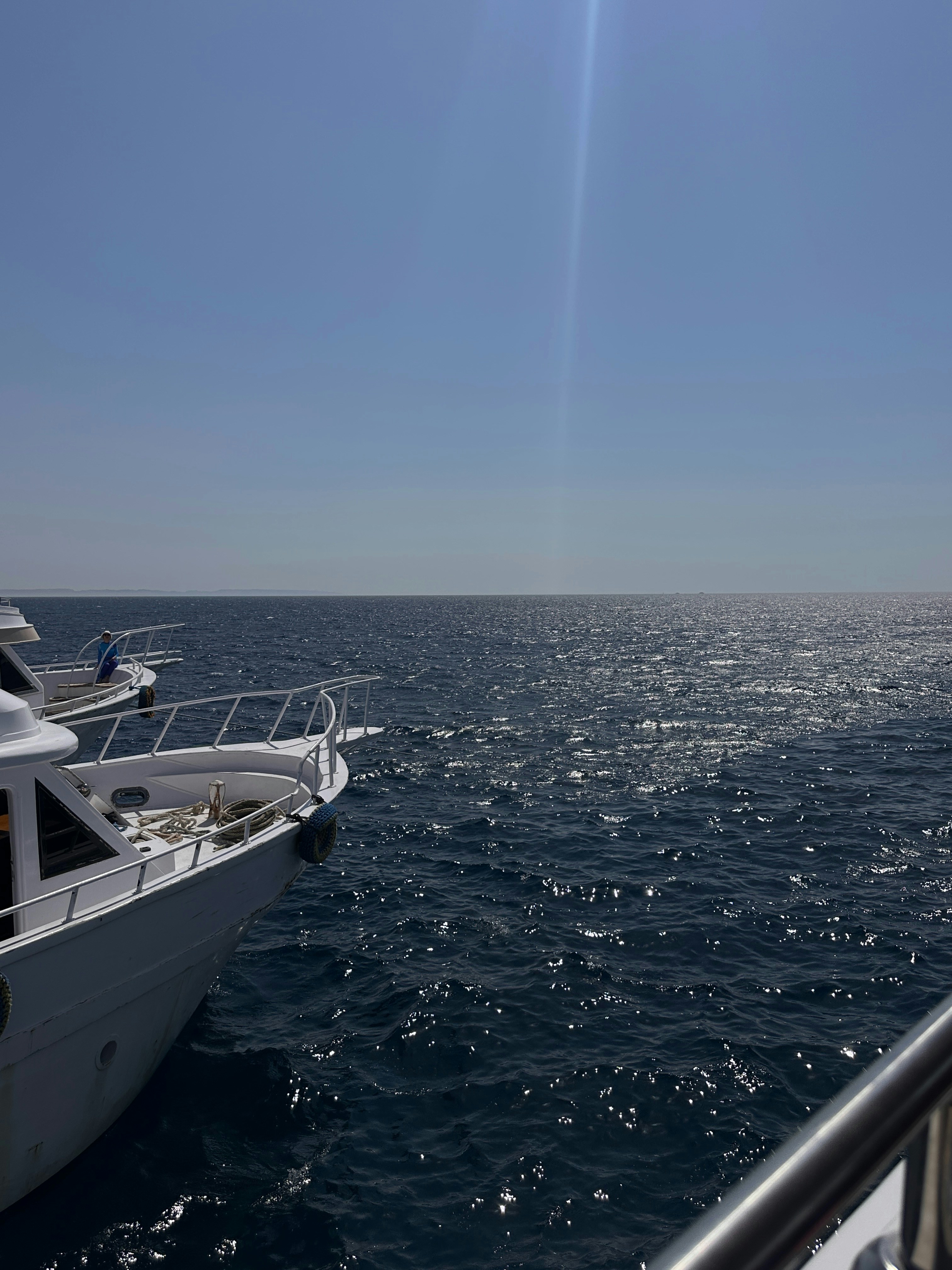 White yachts floating on sparkling blue ocean water.