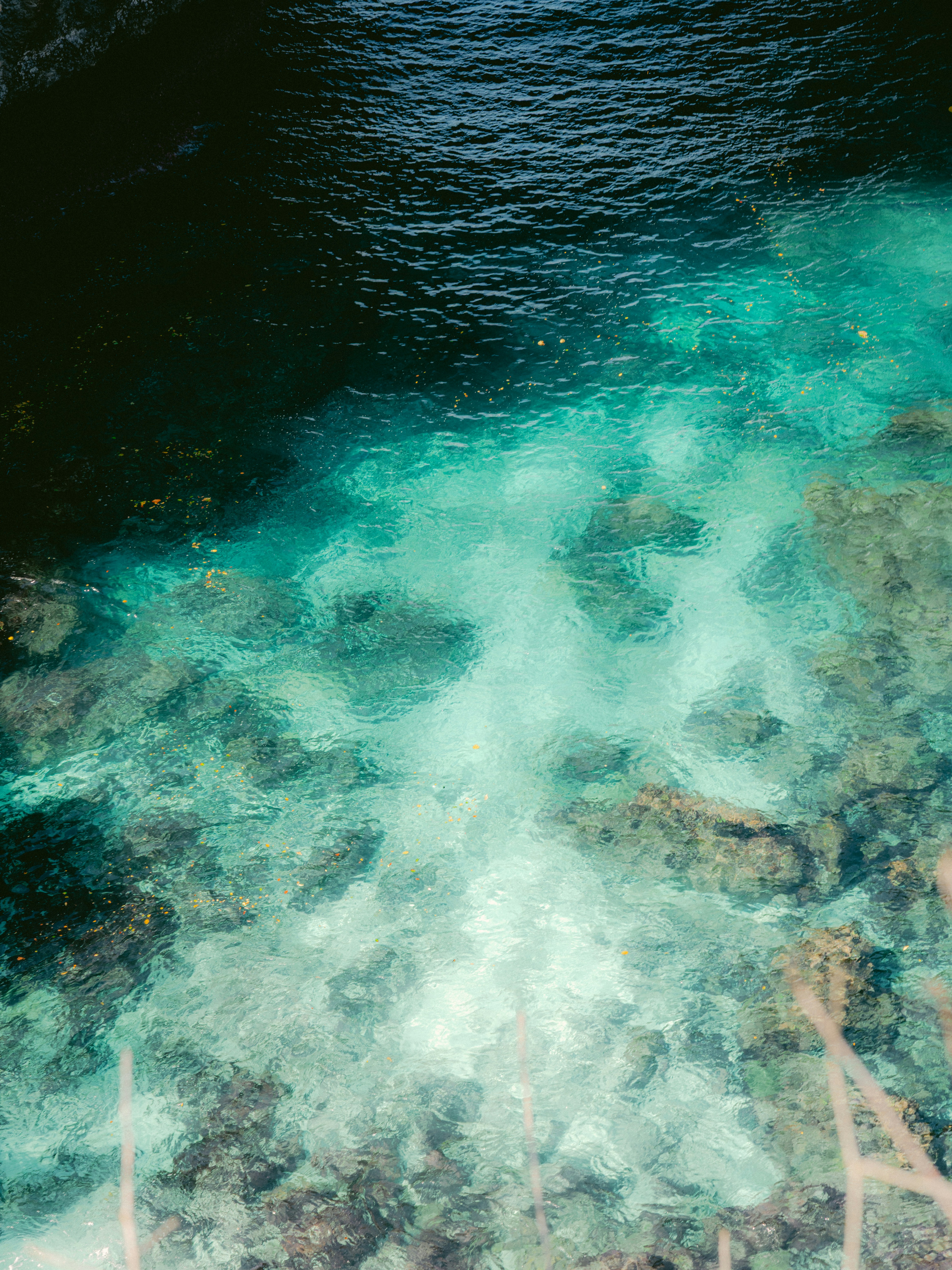 Clear turquoise water over rocky seabed from above
