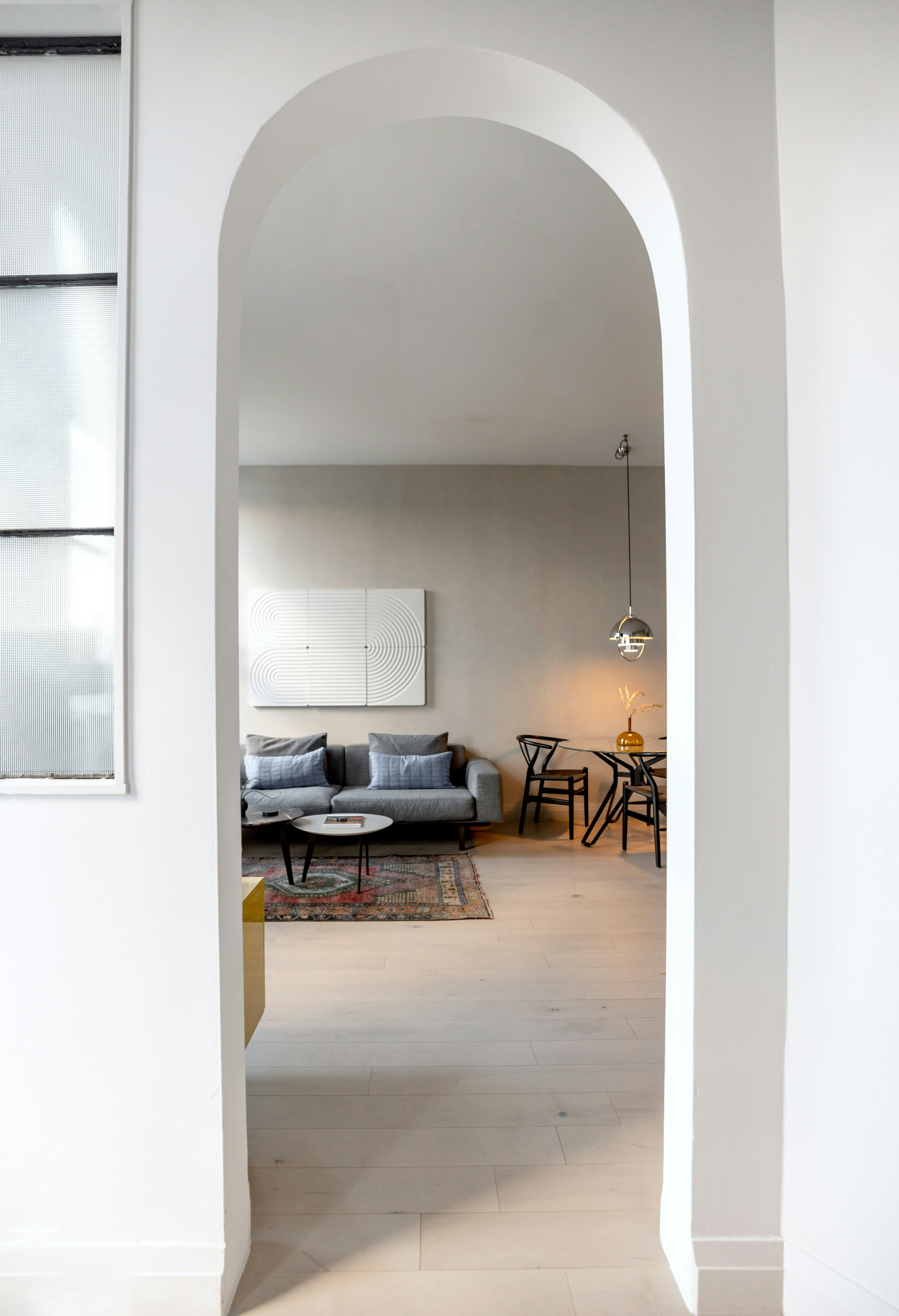 Modern apartment hotel in the city | Modern living room and dining area seen through archway through arch