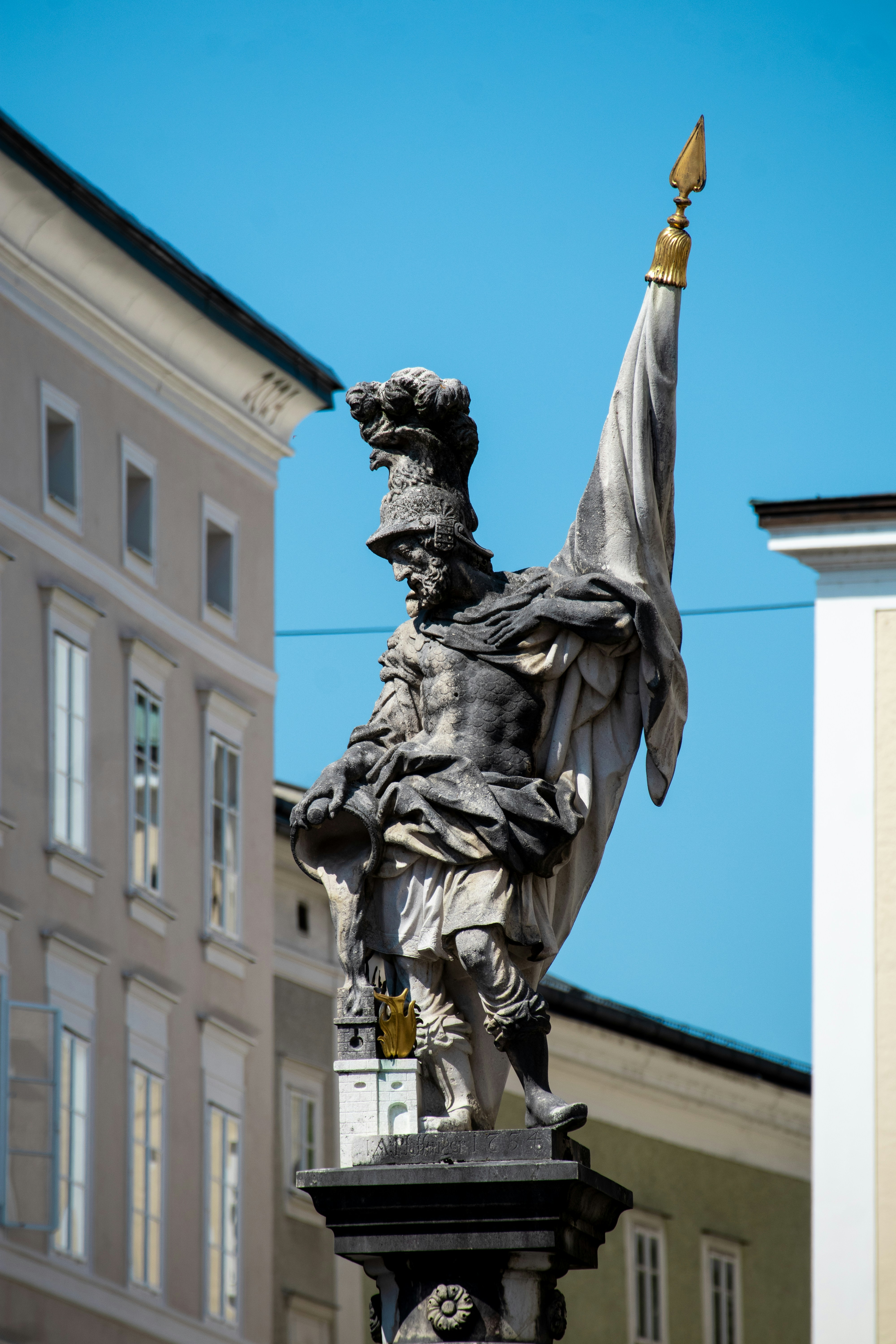 Stone statue of a man holding a flag