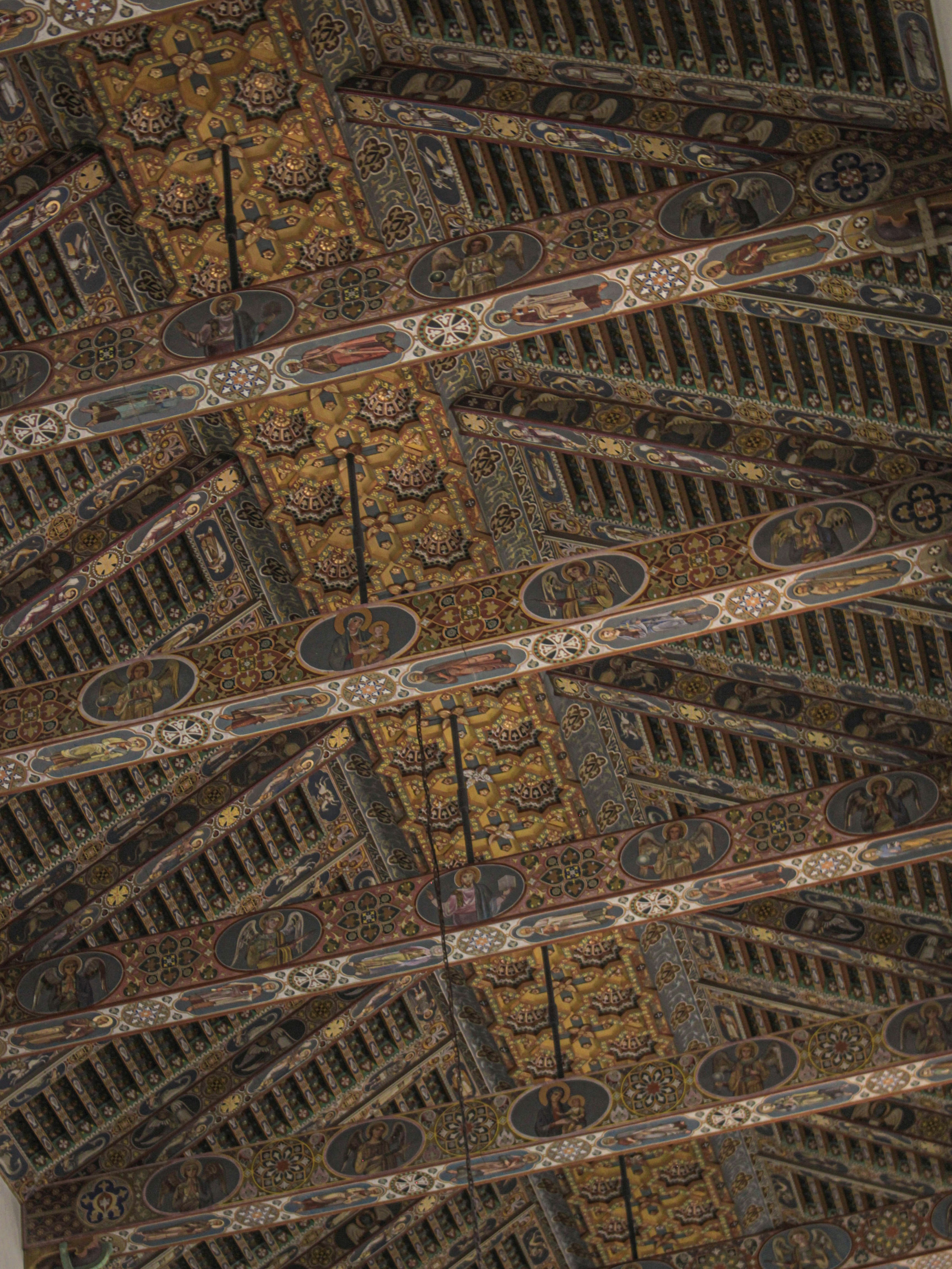 Intricate wooden ceiling with ornate carvings and colorful patterns.