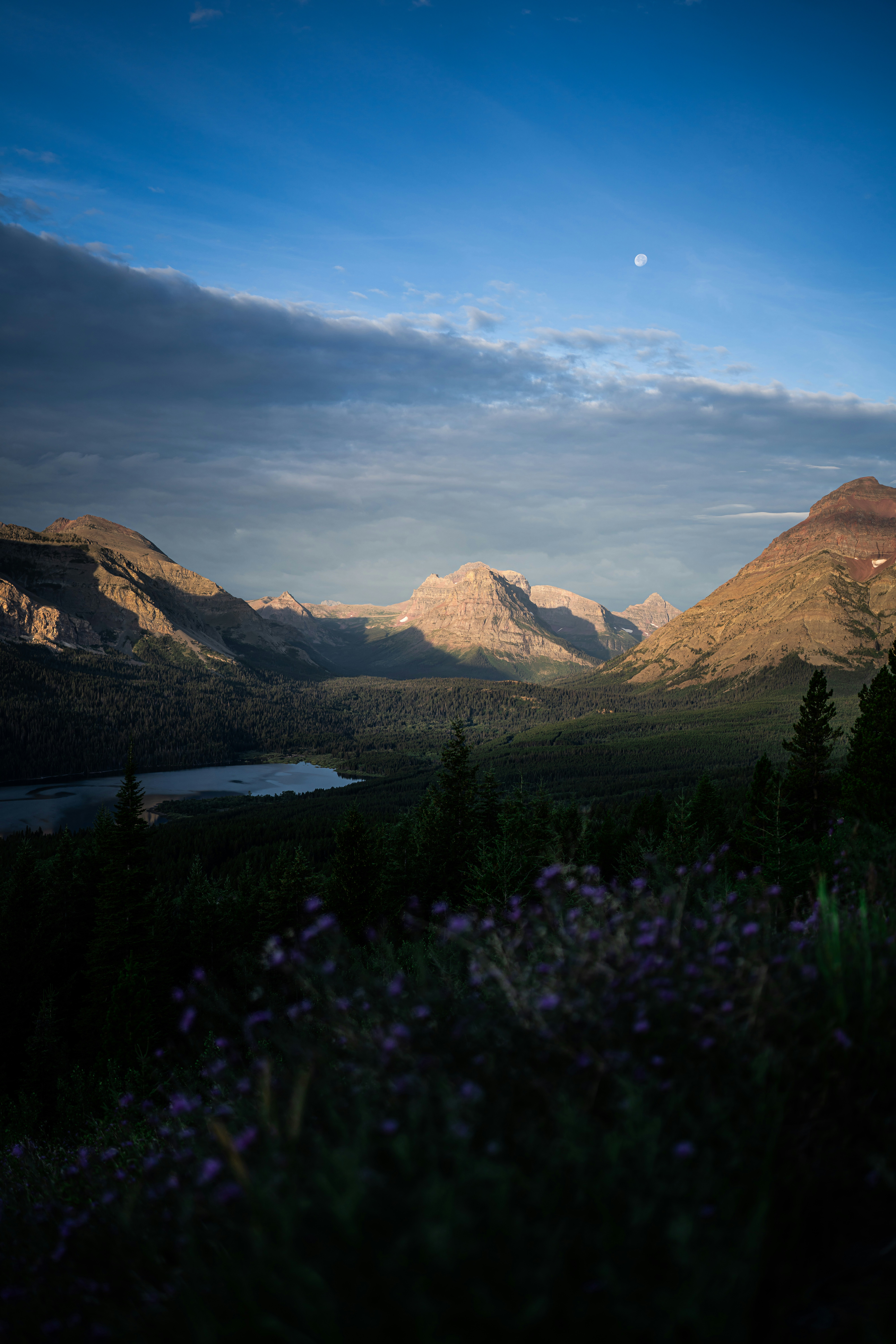 Sunlit mountains and valley under a twilight sky