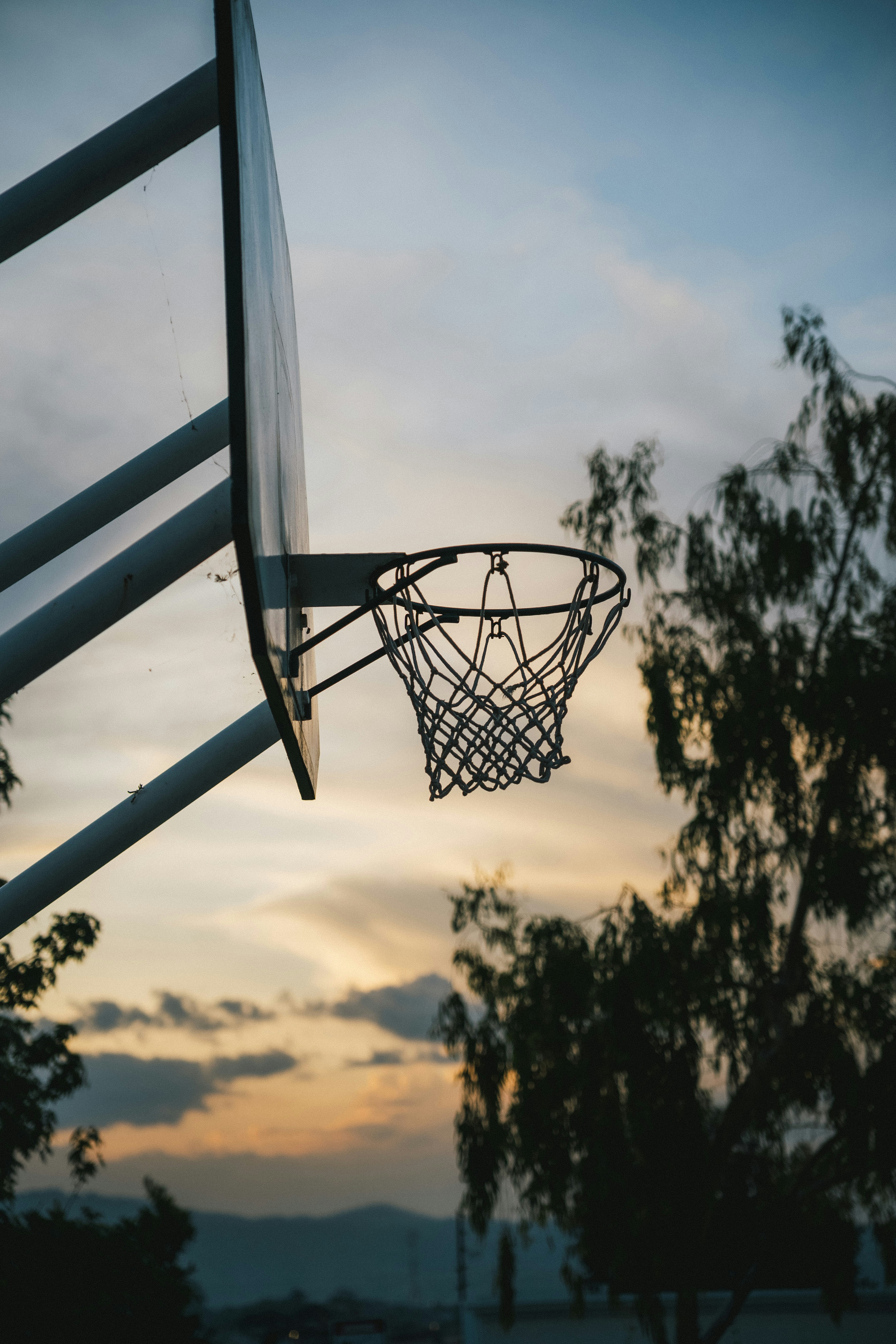 Basketball hoop against a sunset sky