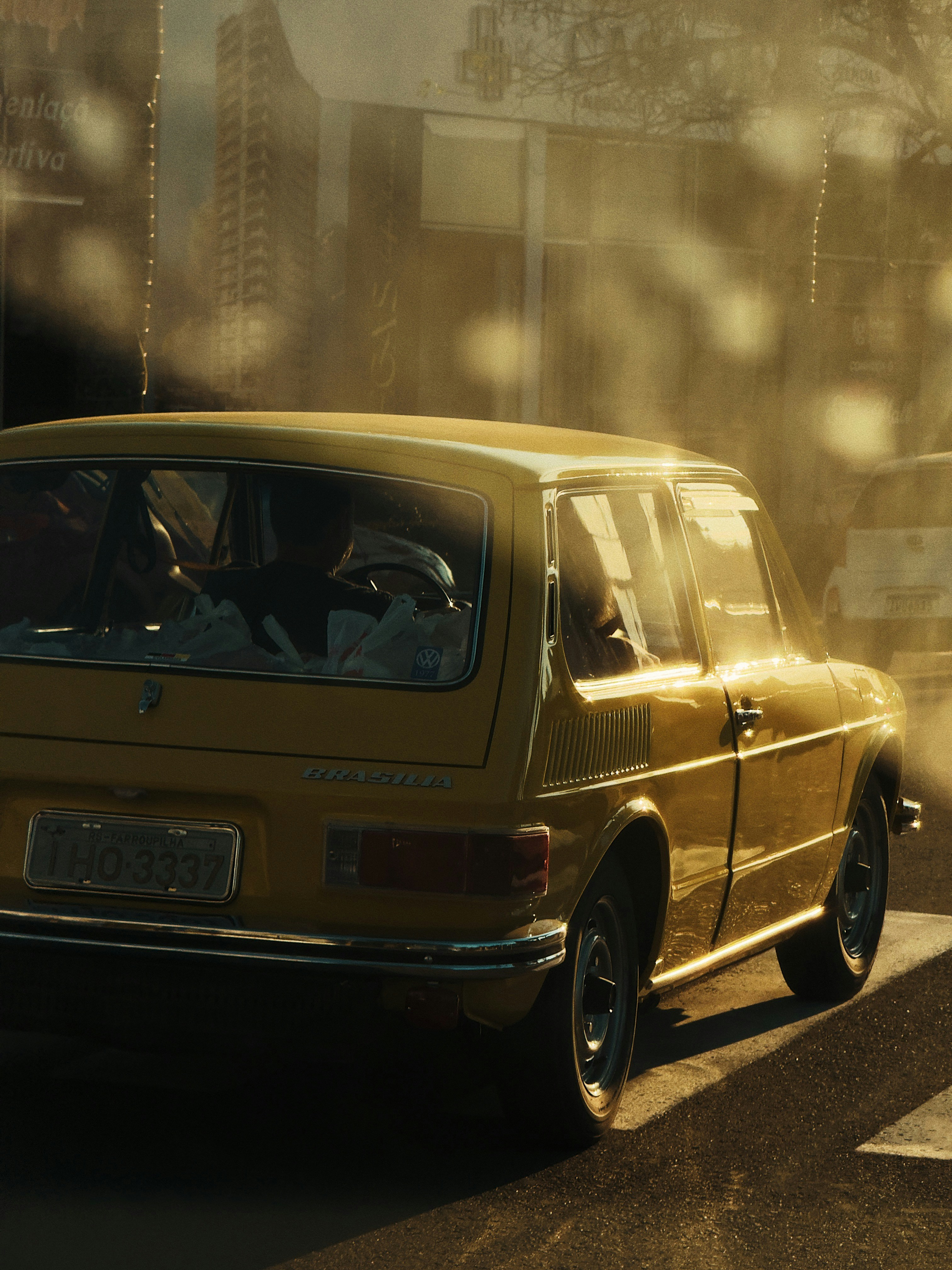 Brasilia Amarela | Yellow car driving on a sunny street.