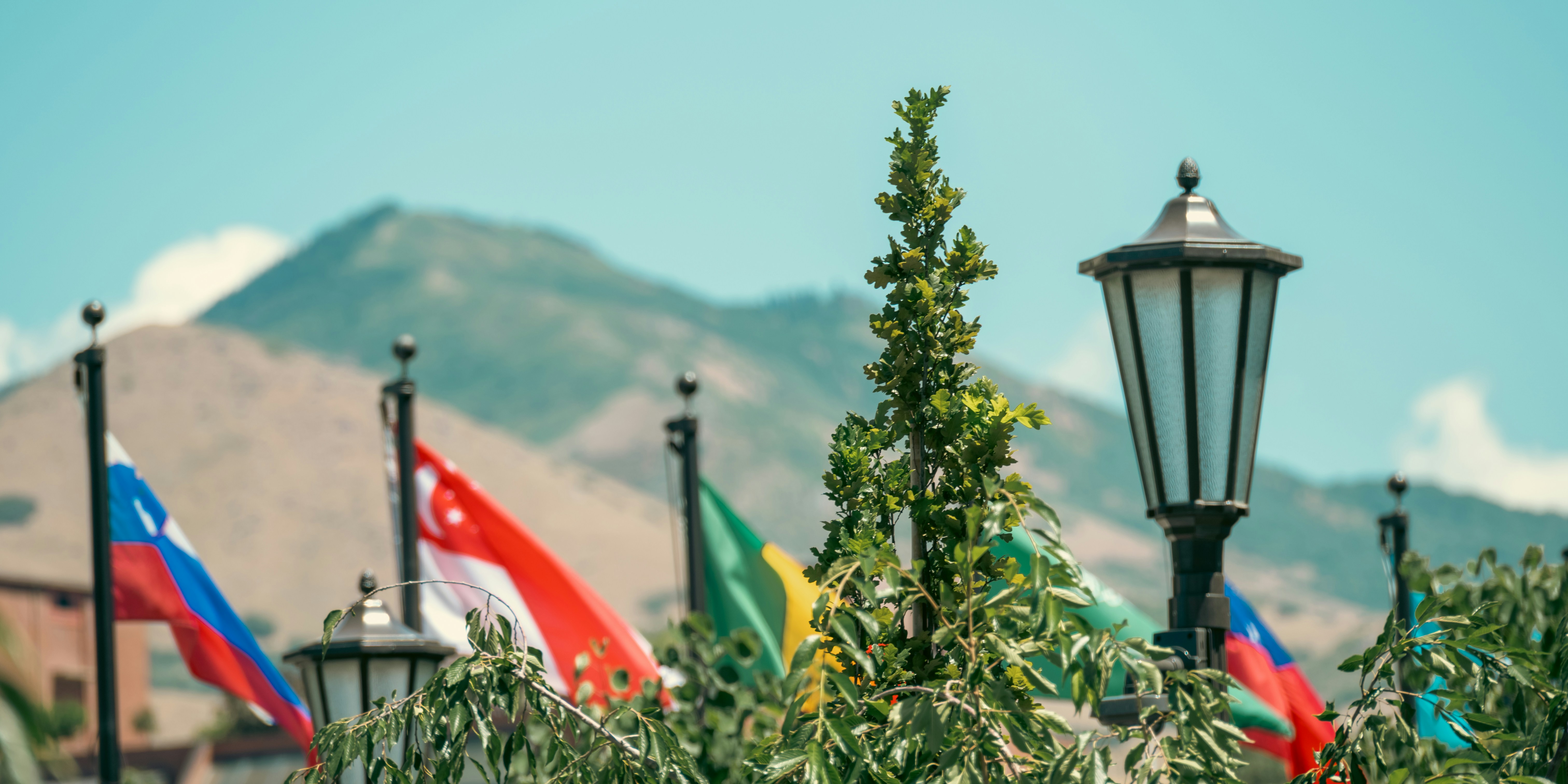 Flags and street lamp with mountain background