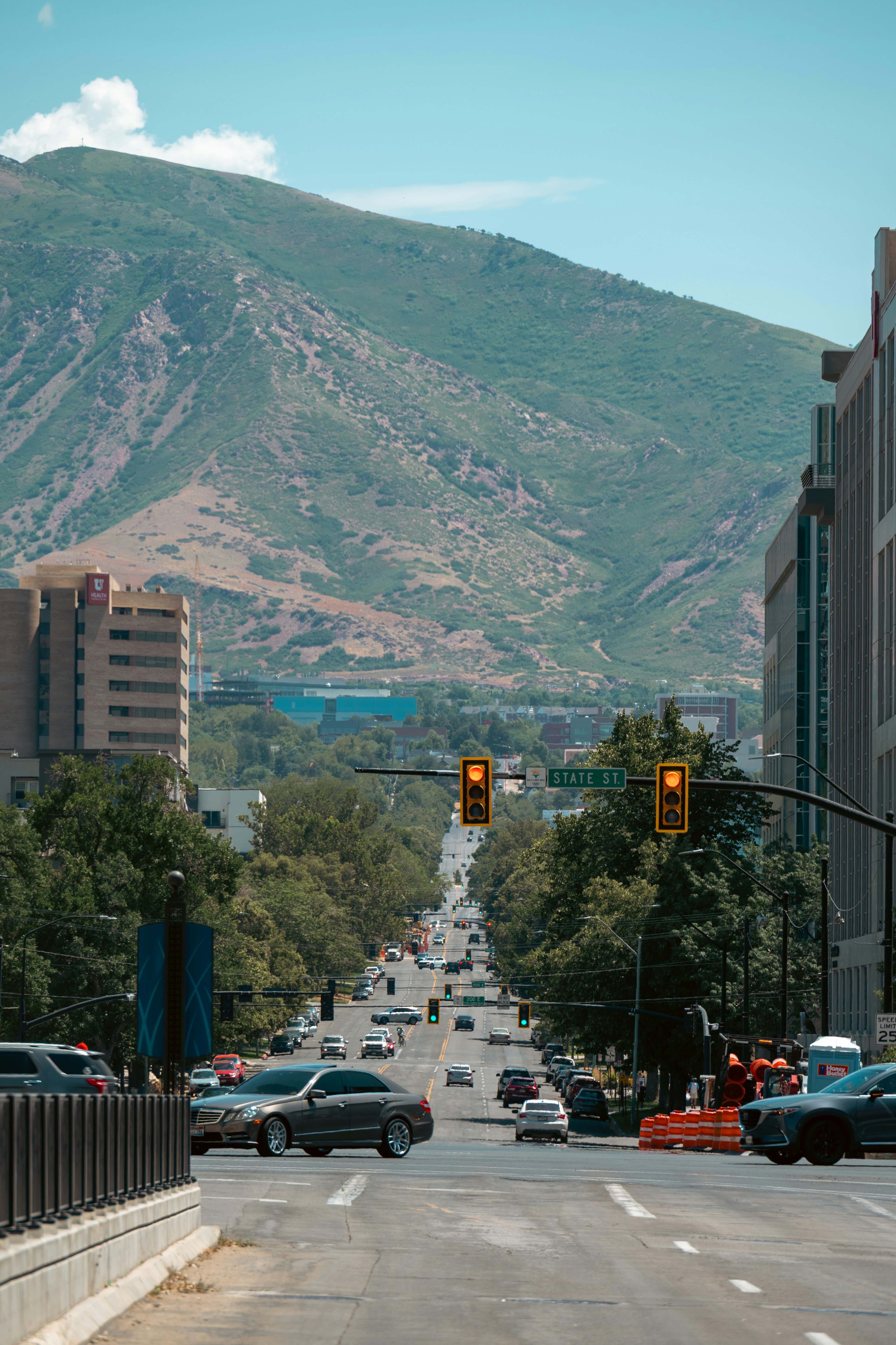 City street leading to a large mountain under a clear sky.