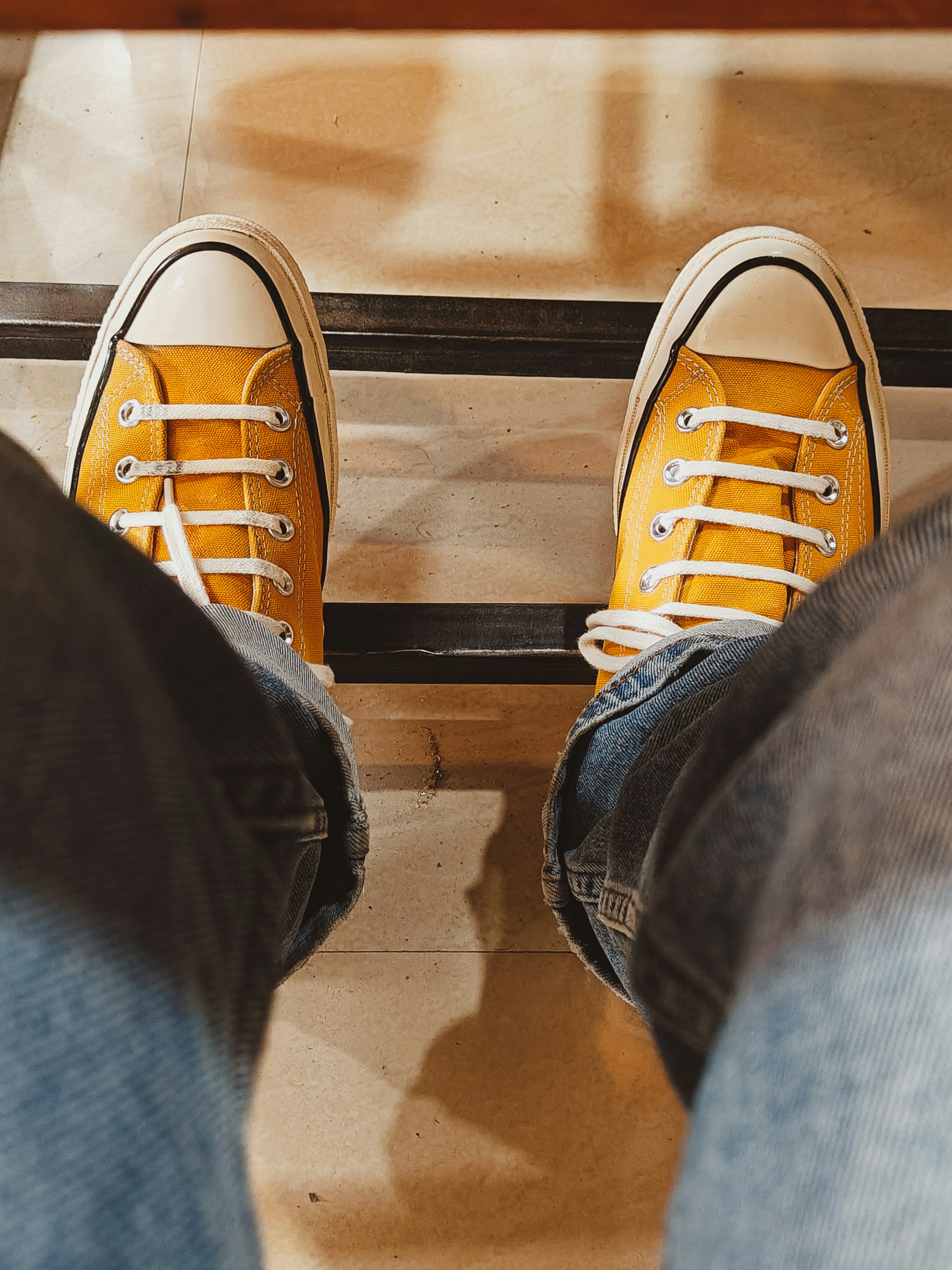 Yellow sneakers and blue jeans on steps