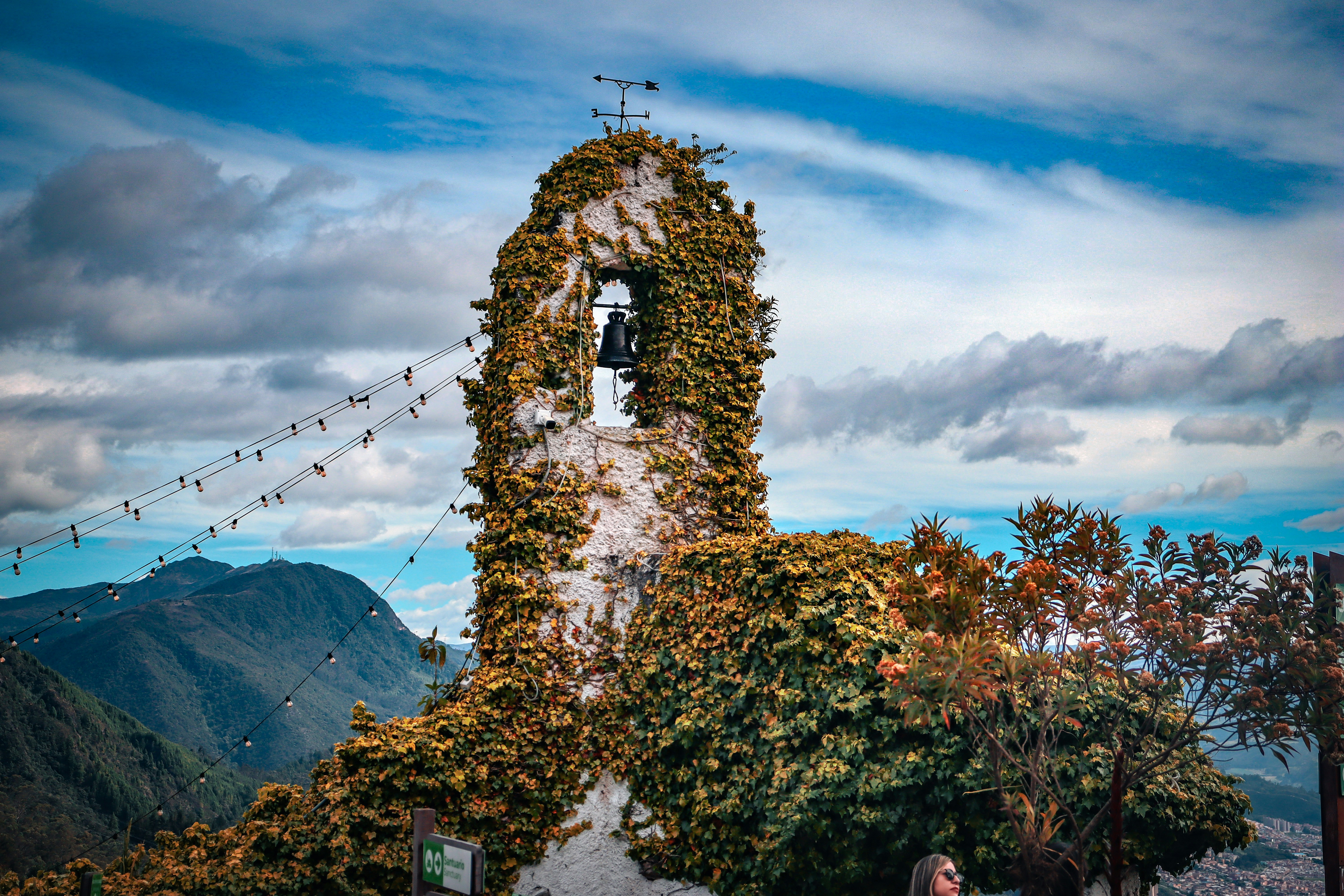 Old stone tower covered in ivy with bell
