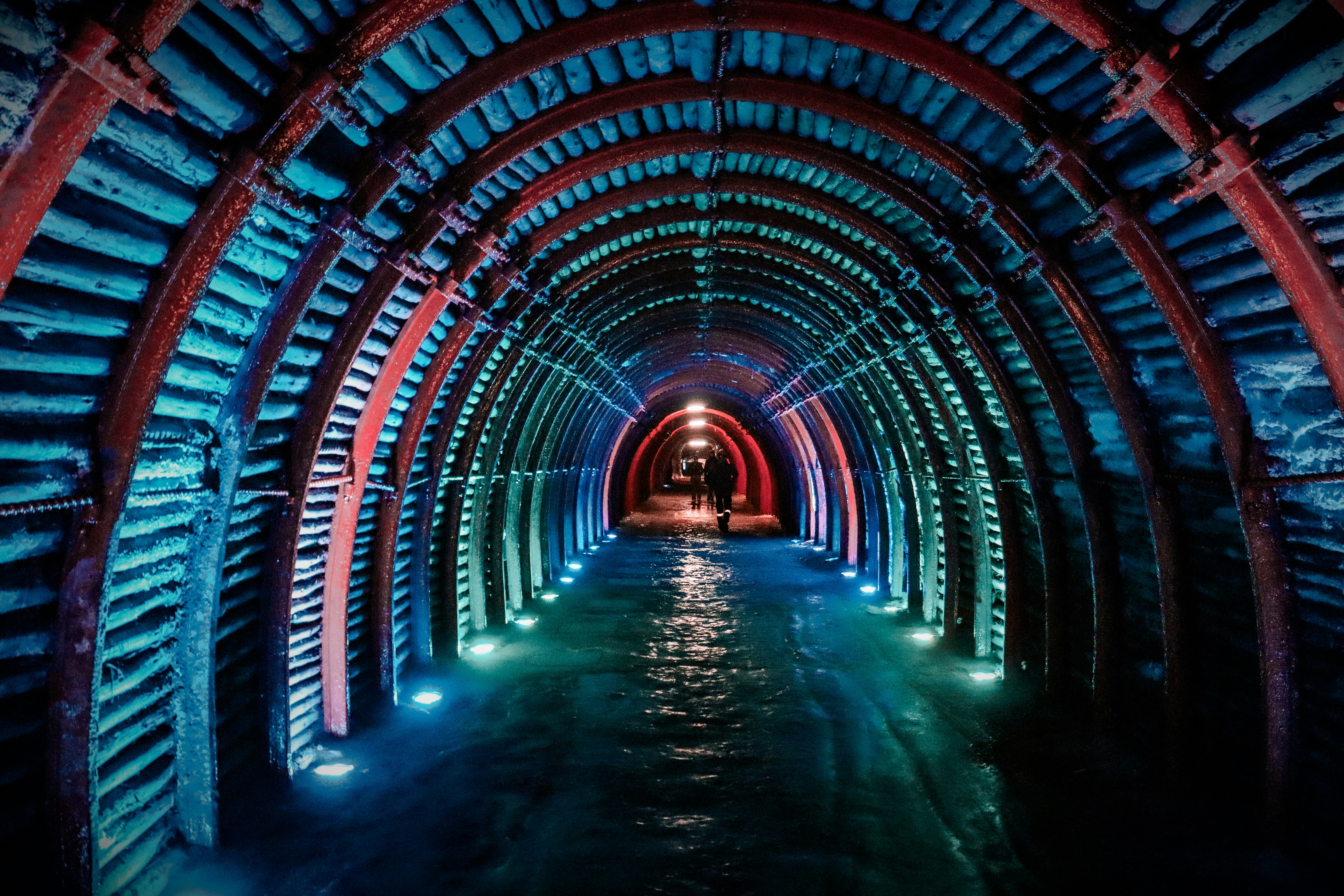 Illuminated tunnel with water reflections and wooden supports