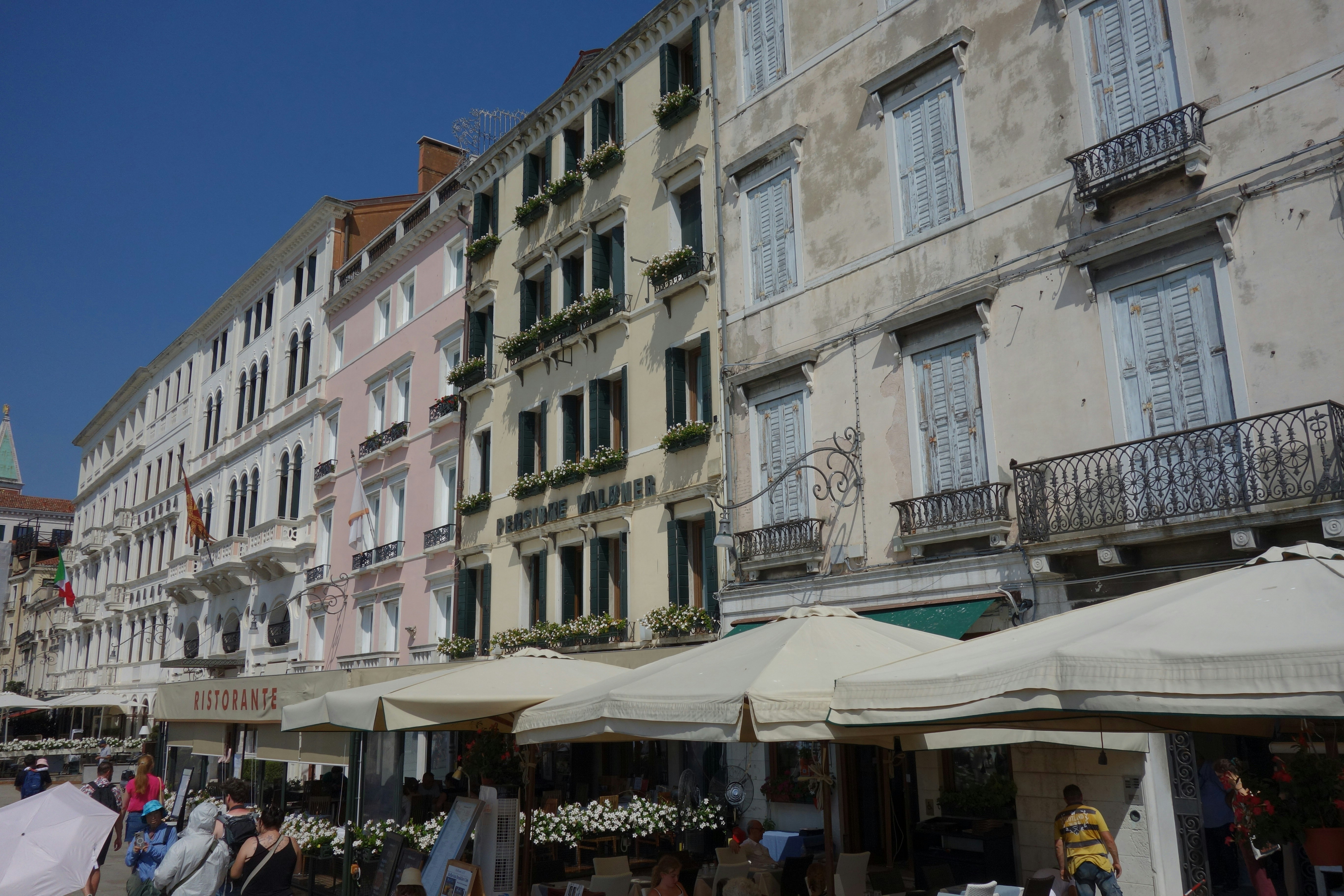Buildings line a street with outdoor market stalls.