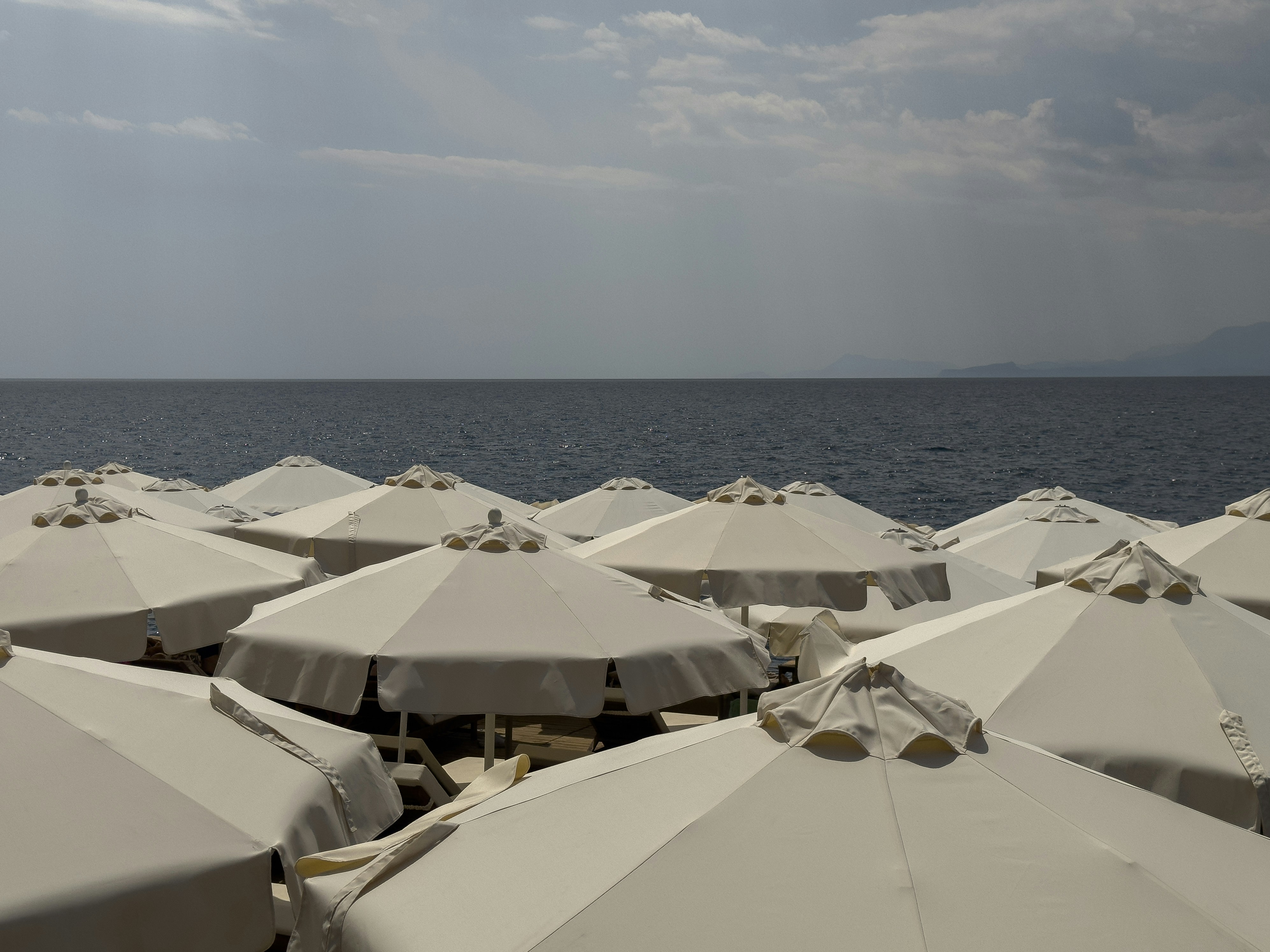 Shade Lines on a Quiet Shore: Umbrella Rows Framing the Open Sea